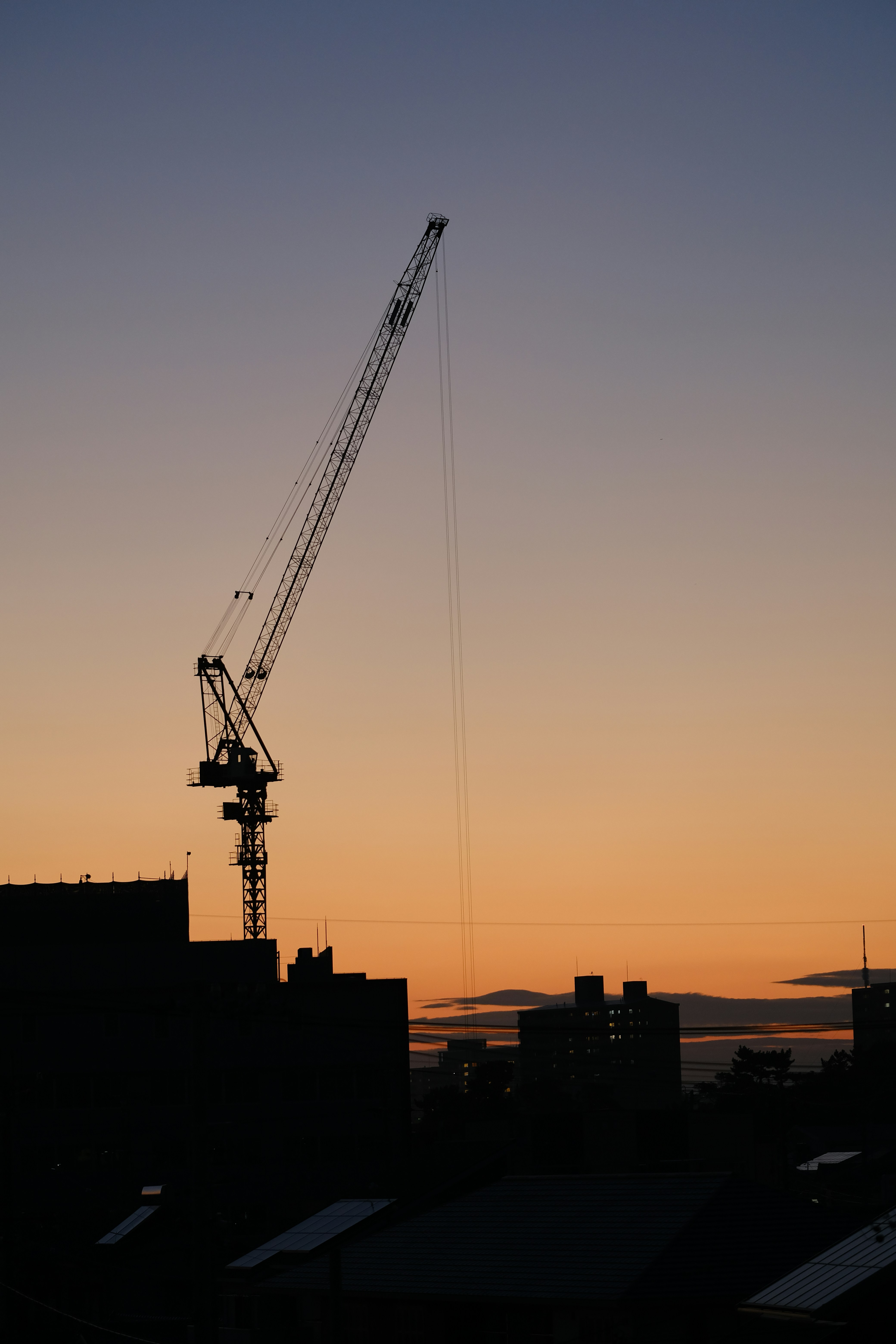 Dusk Crane Silhouette Over a Quiet City Skyline