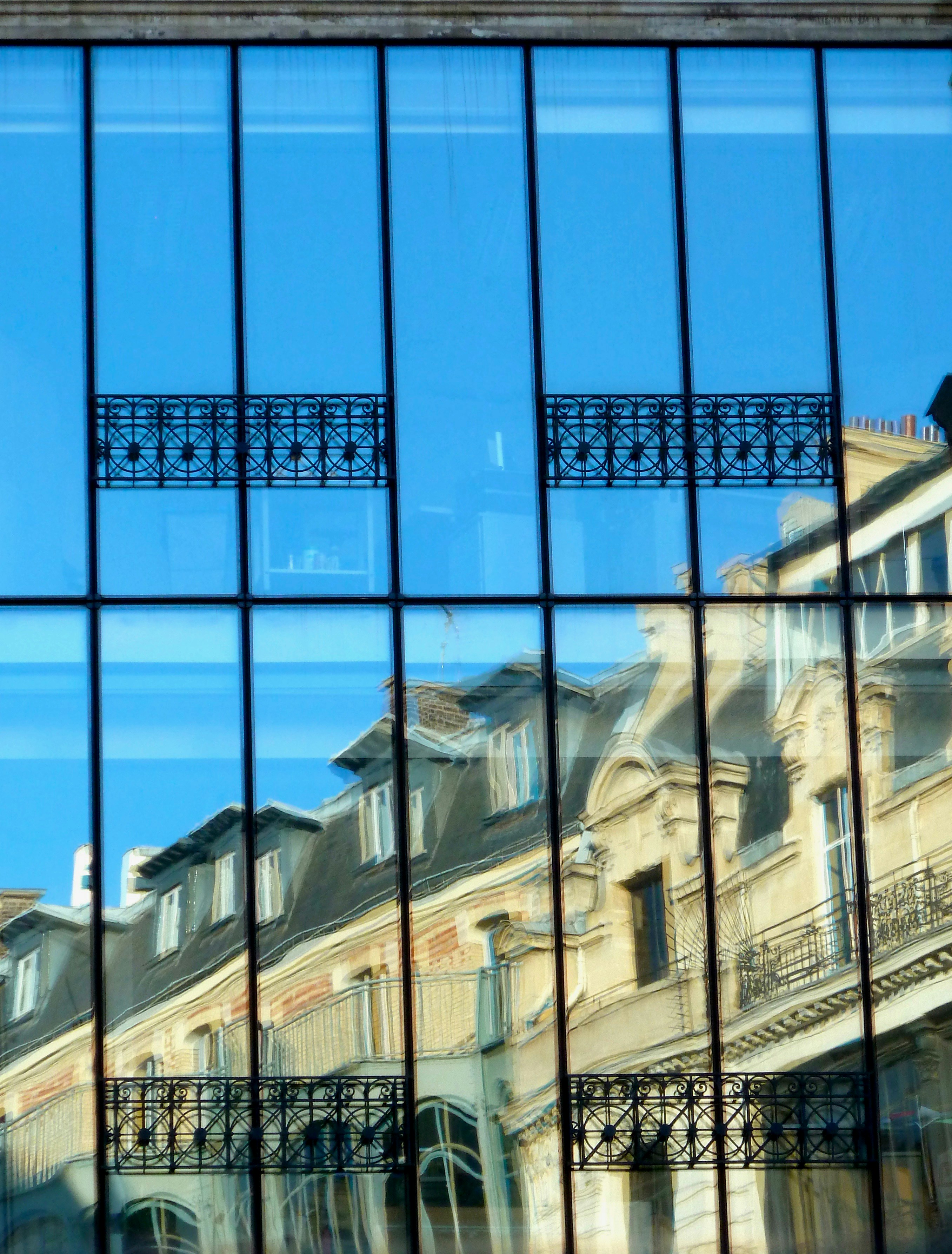 Blue Grid Reflections: Glass Facade Mirroring Historic Architecture