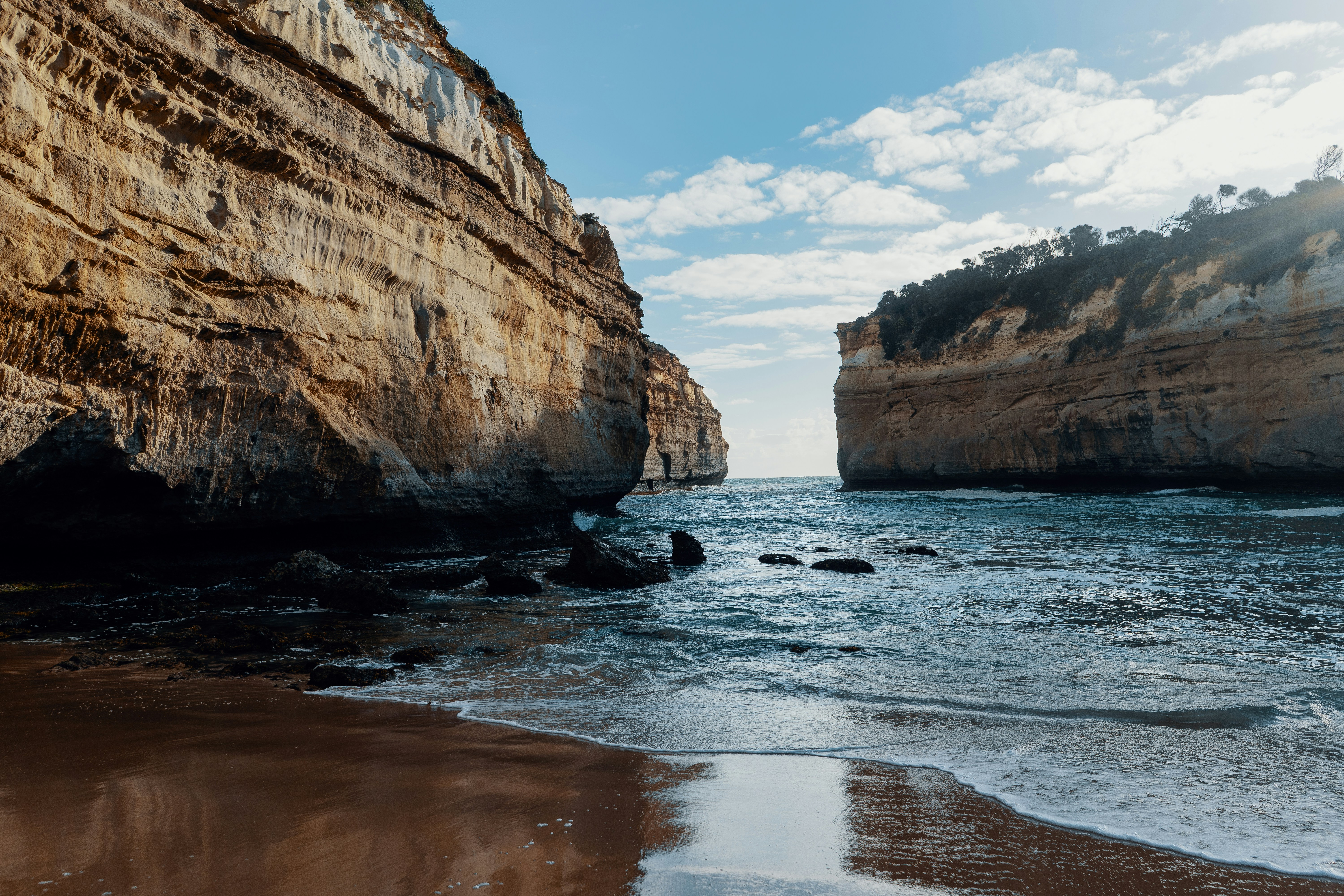 Brown rock formation on sea water under blue sky during daytime photo ...