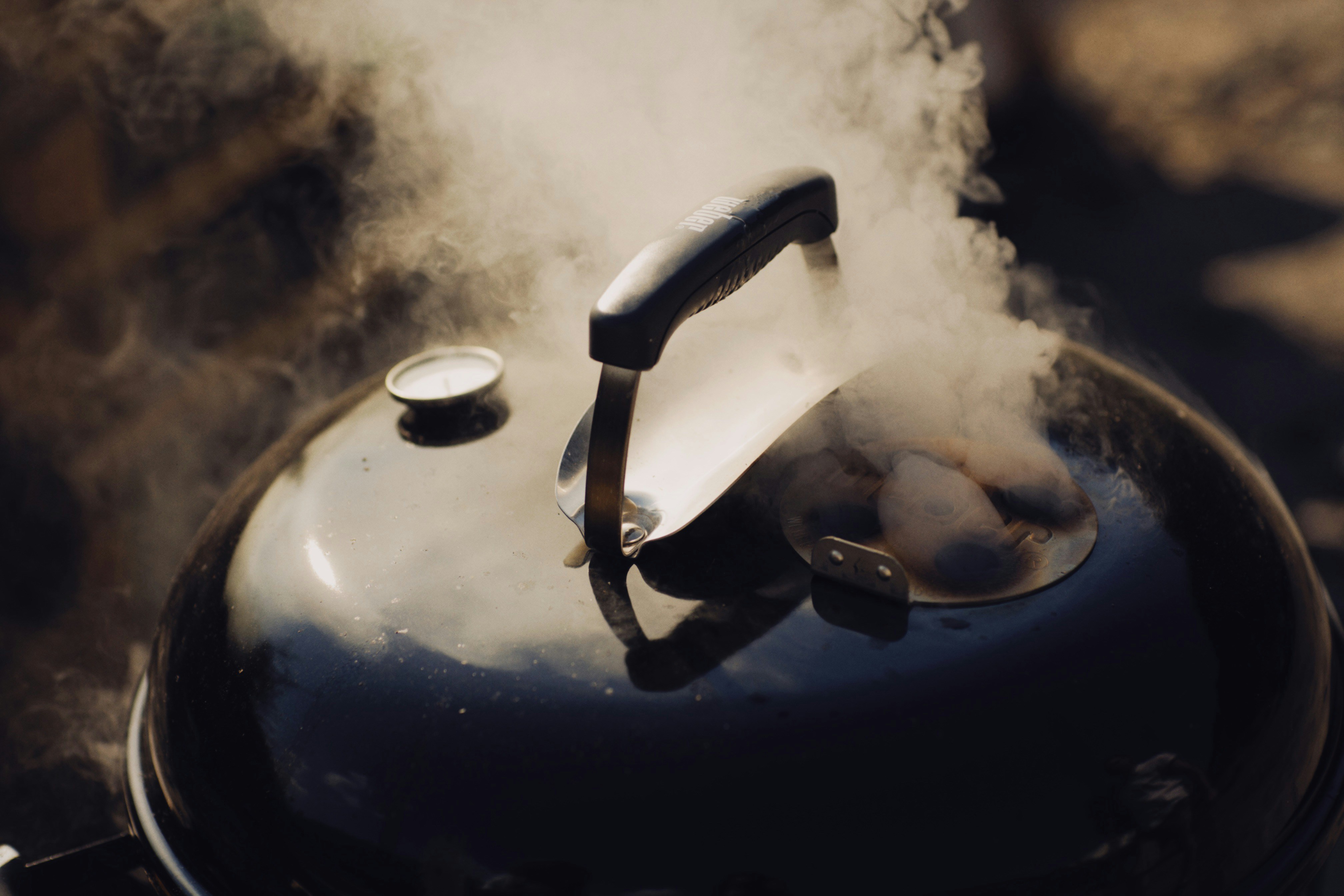 Steam Crown: Close-Up of a Kettle Lid and Handle on a Quiet Grill