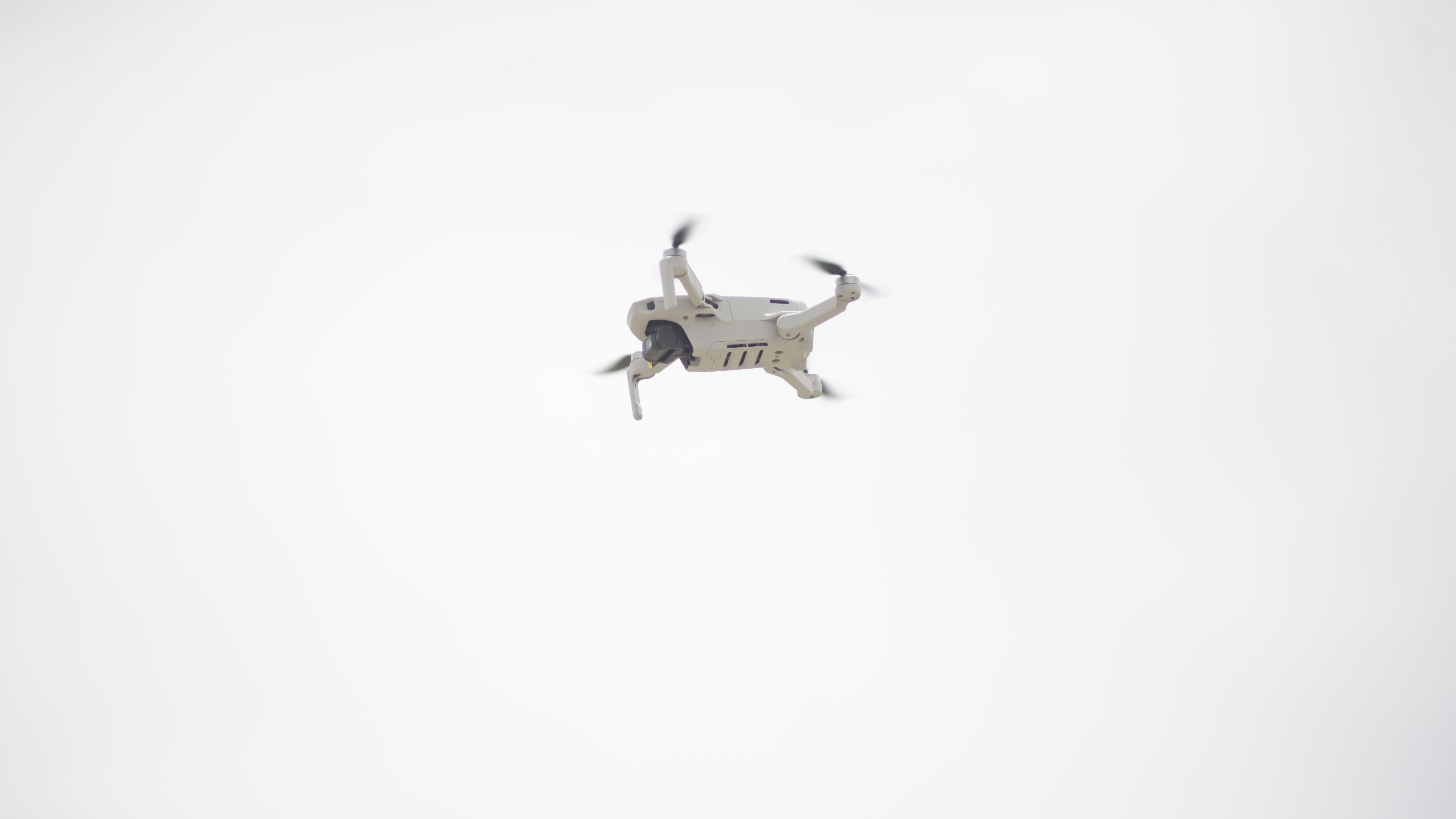Nimbus Drift: A Compact Quadrotor Hovering in a Pale, Featureless Sky