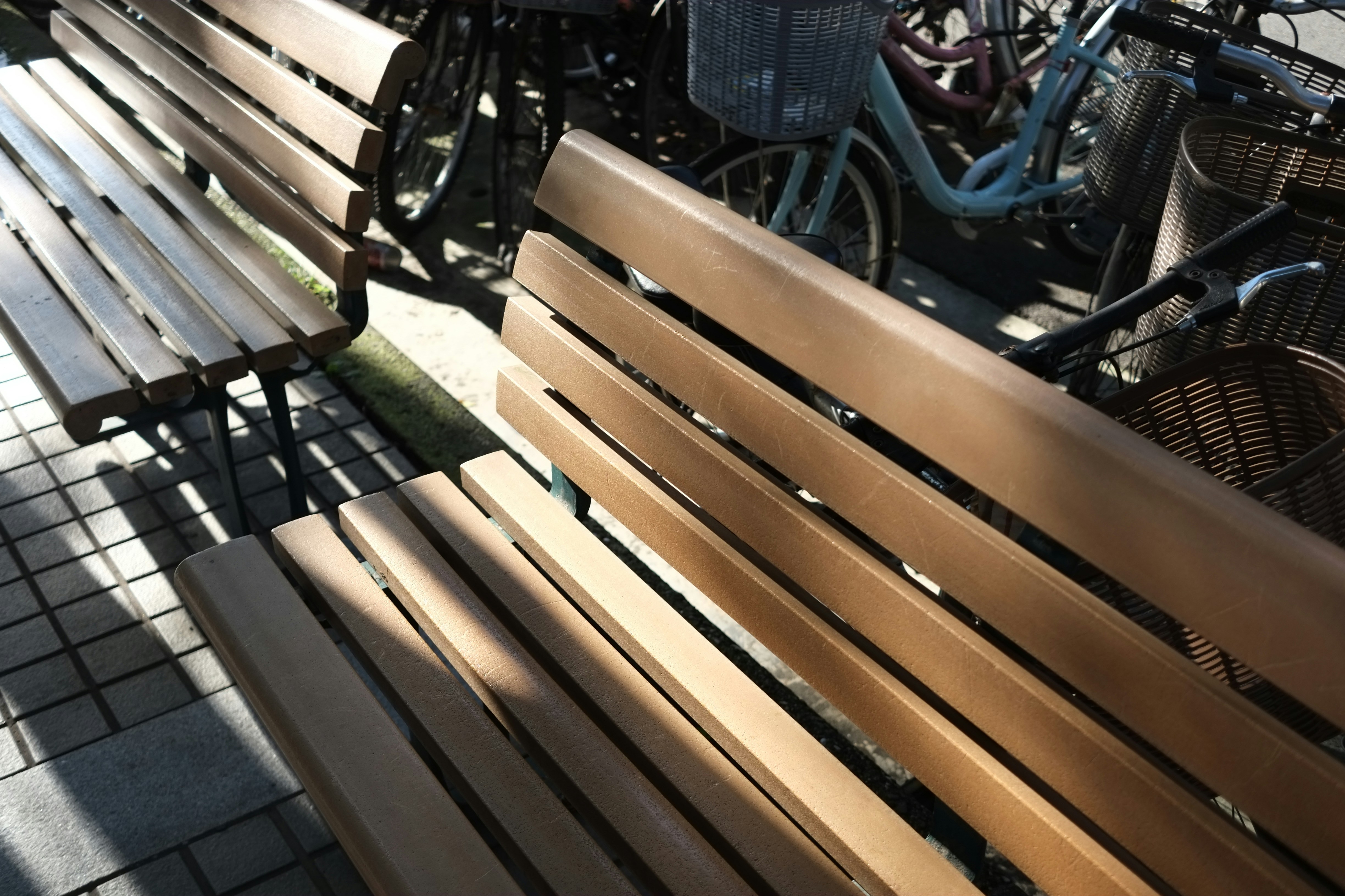 brown wooden bench near black bicycle