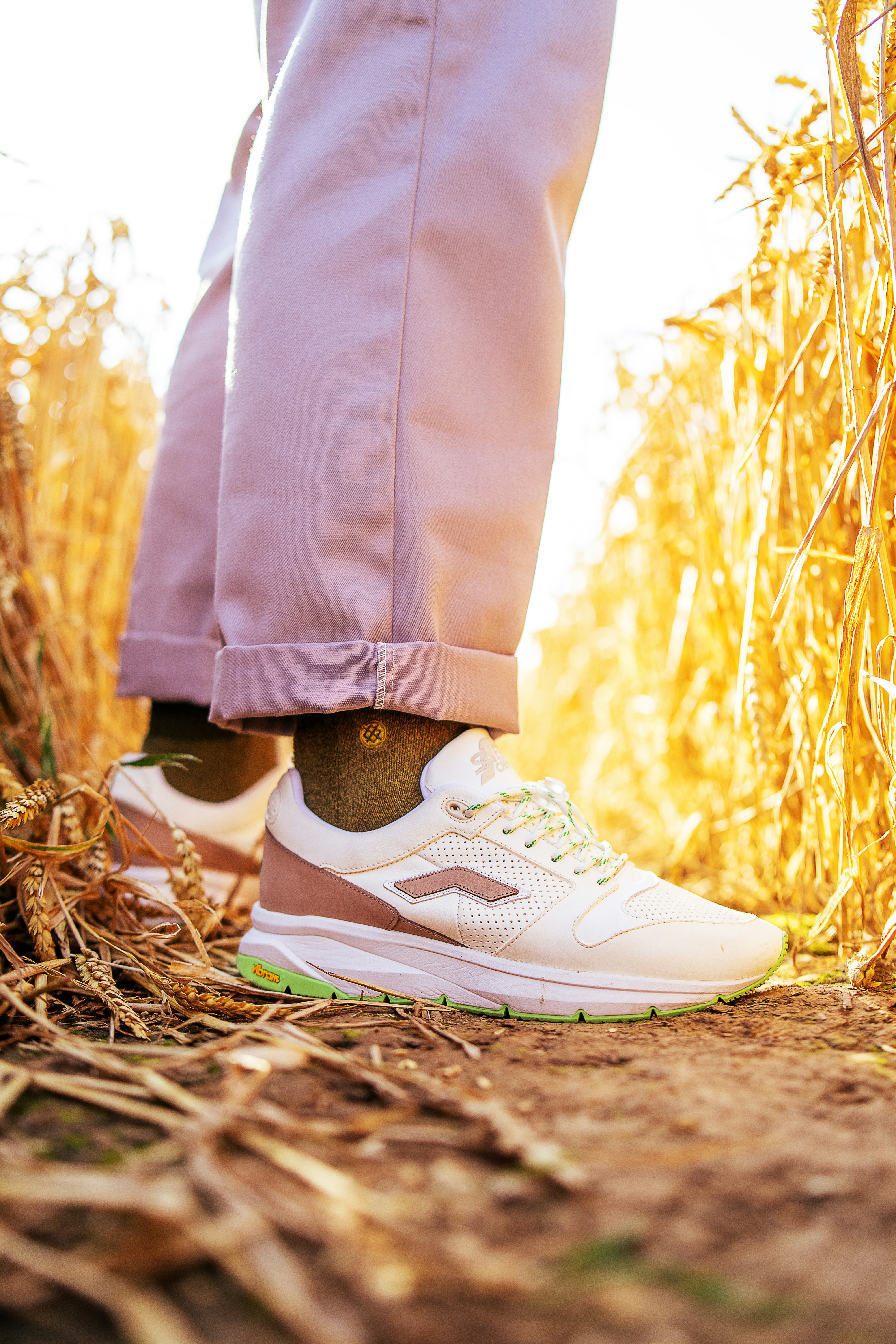 Golden Hour Footing: Cream Sneakers Crossing a Sunlit Field