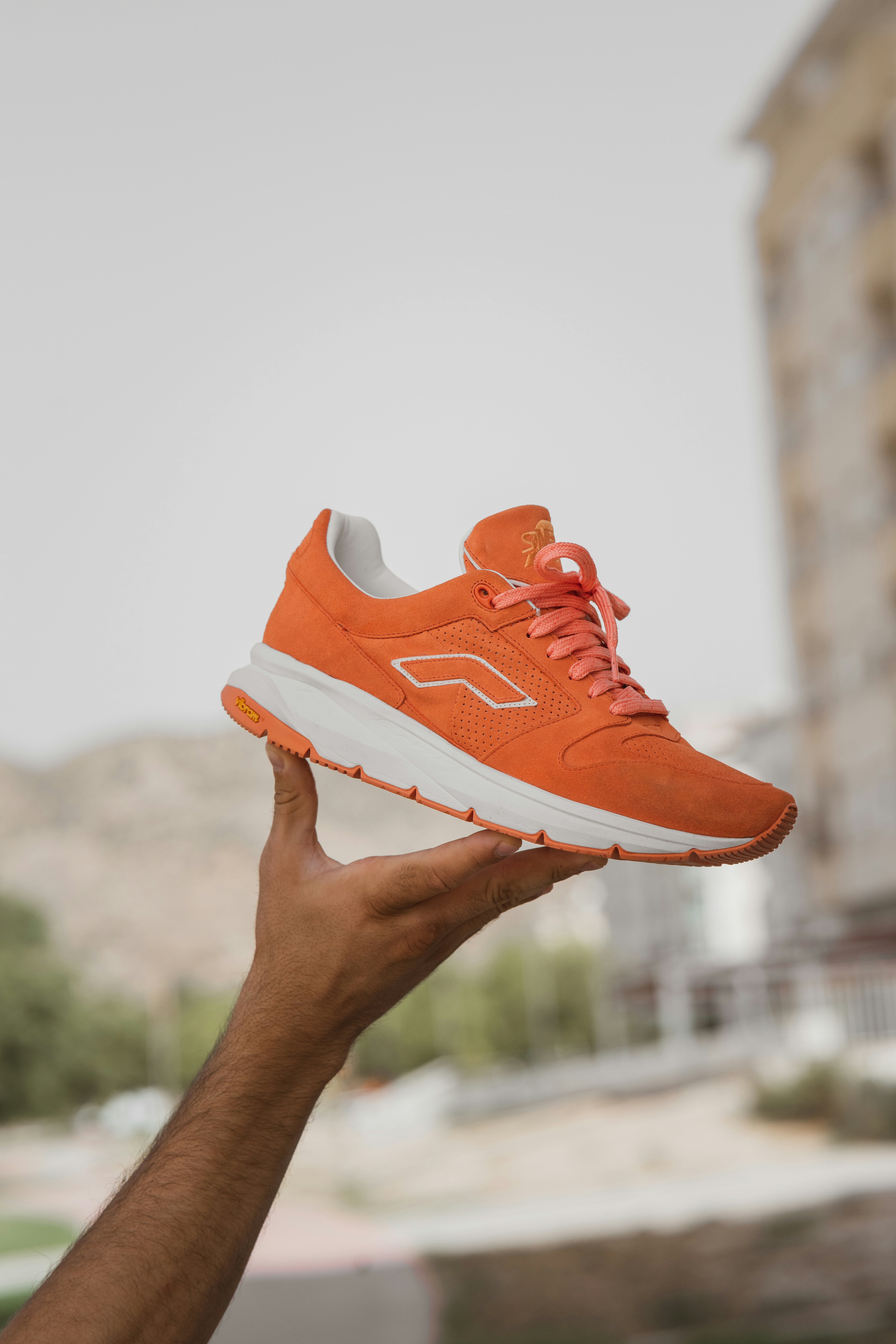 Orange Sneaker Lift: Crisp Detail Against a Velvet City Blur