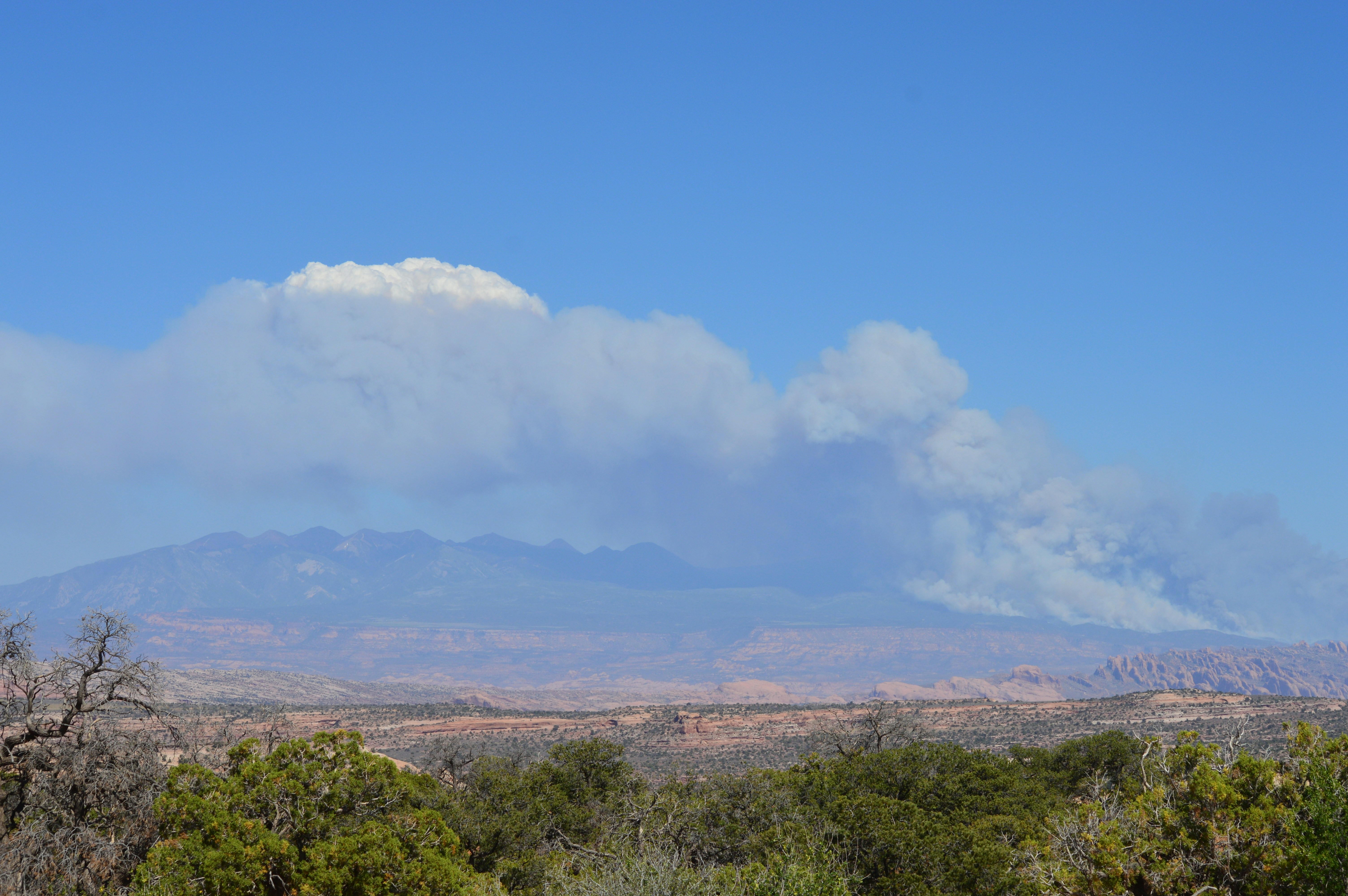 Distant Plume Rises Over a Quiet Desert Horizon