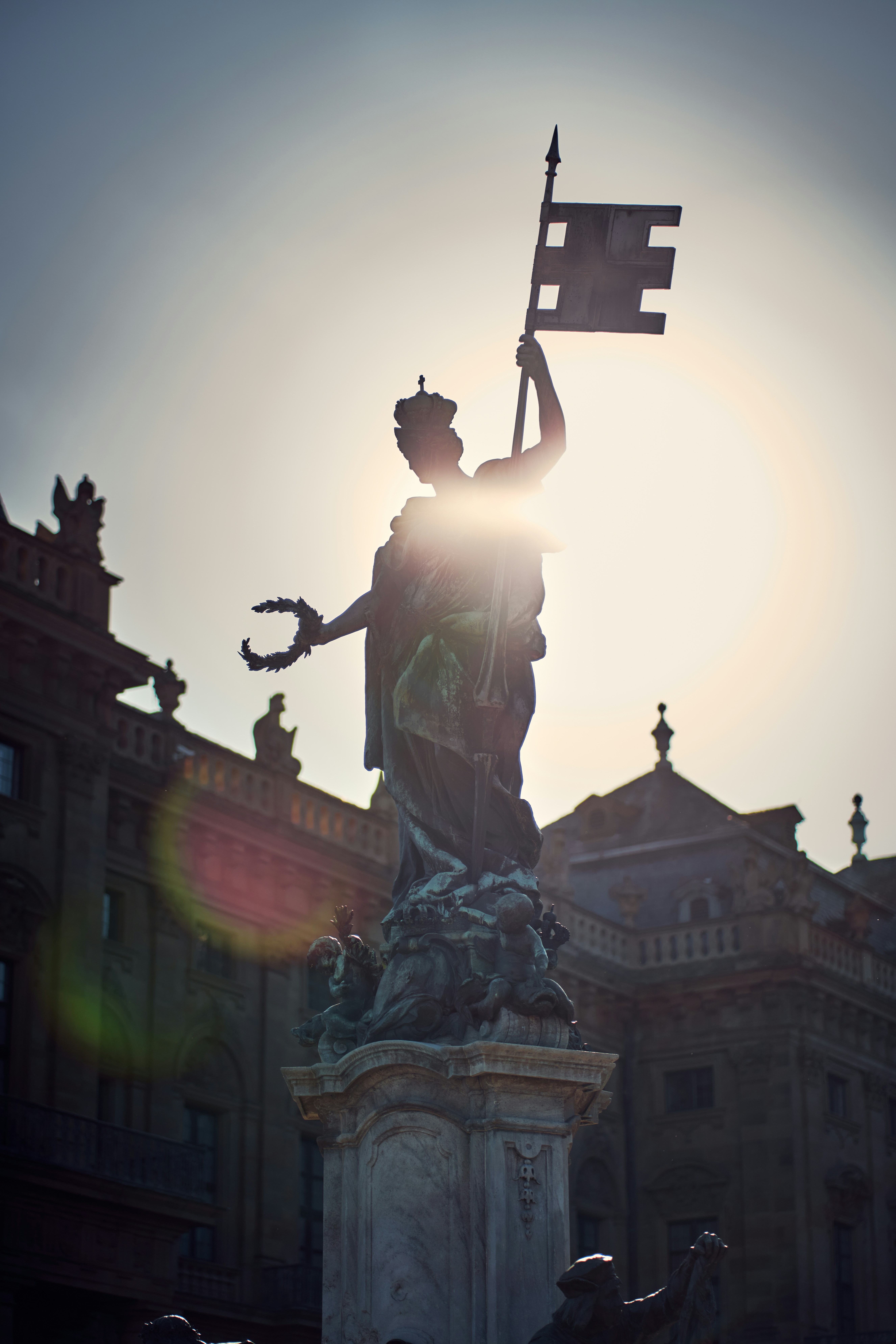 The statue in front of the residence in Würzburg, behind it the morning sun.