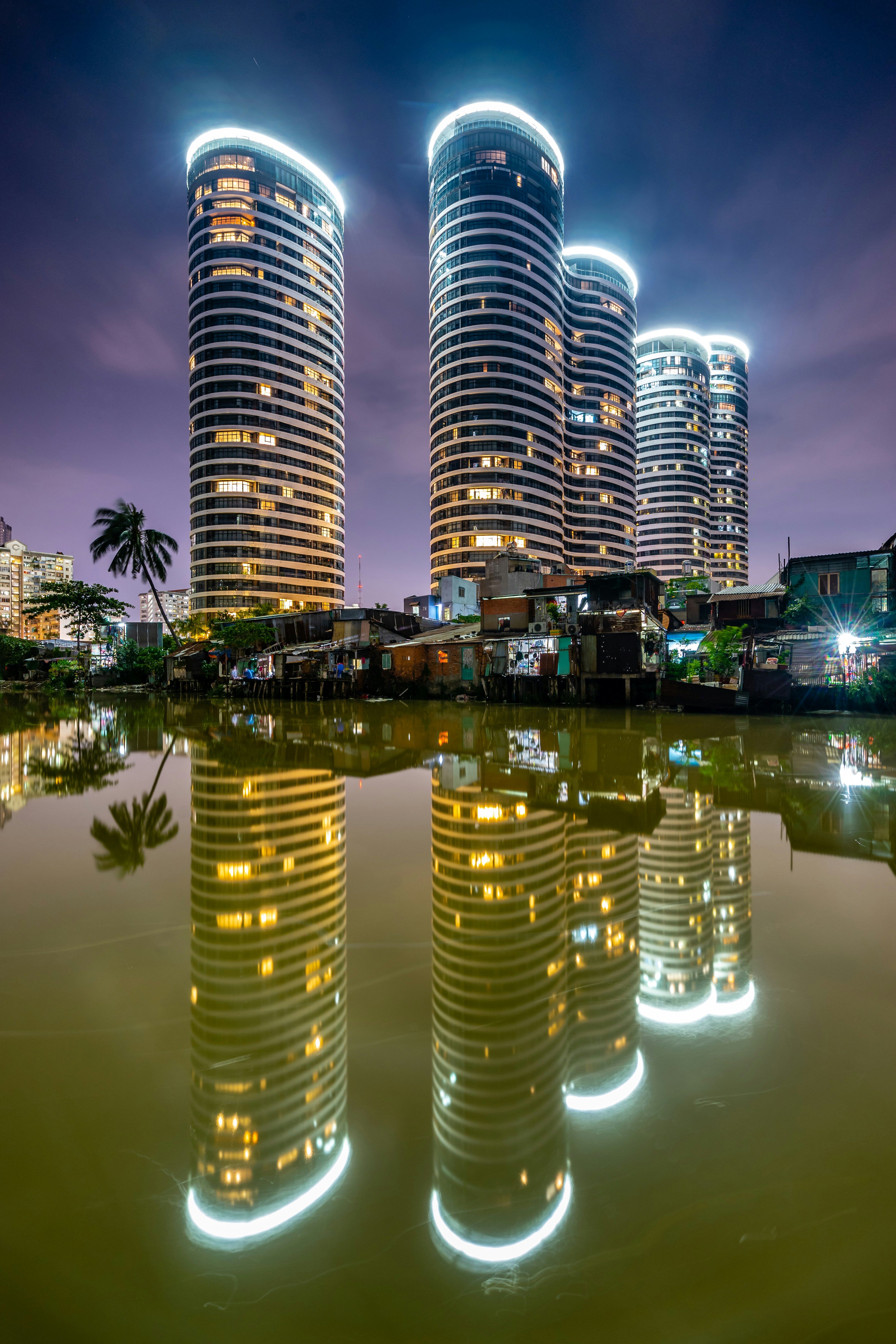 Reflection of lighted buildings on water during night time photo – Free ...