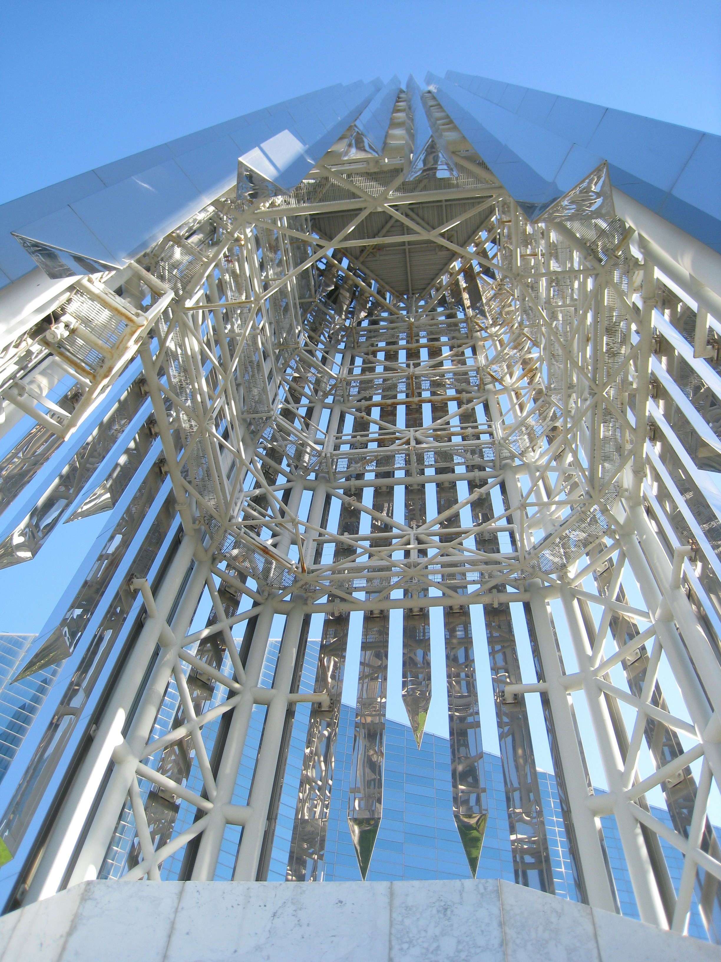 Intricate metallic framework soaring towards the sky, framed by a clear blue backdrop. The design showcases modern architectural elegance.