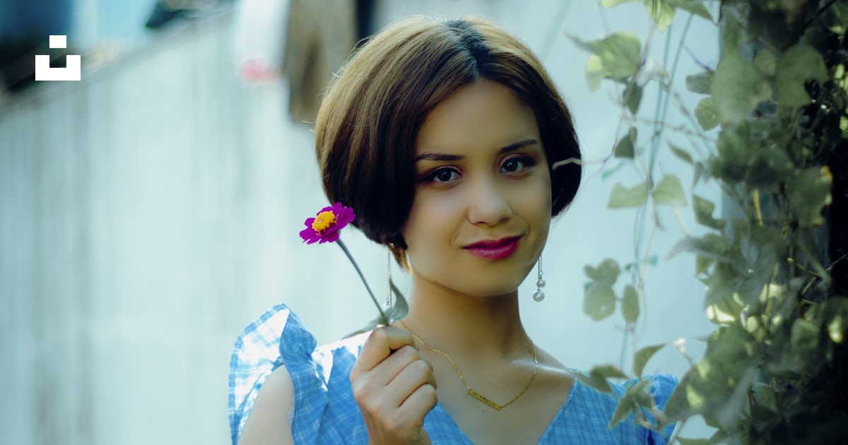 Woman In Blue Sleeveless Dress Holding Purple Flower Photo Free