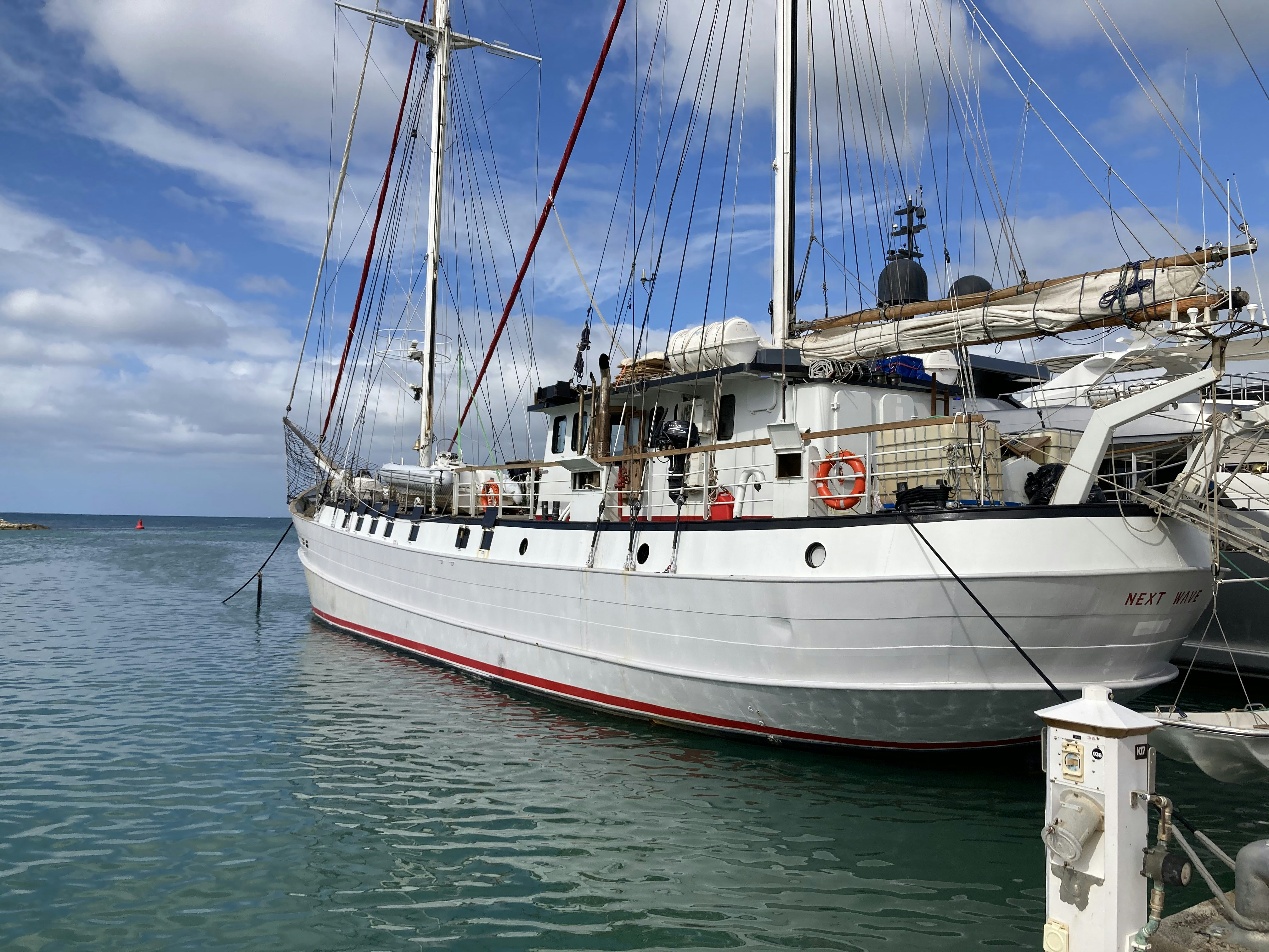 white and red boat on sea under blue sky during daytime