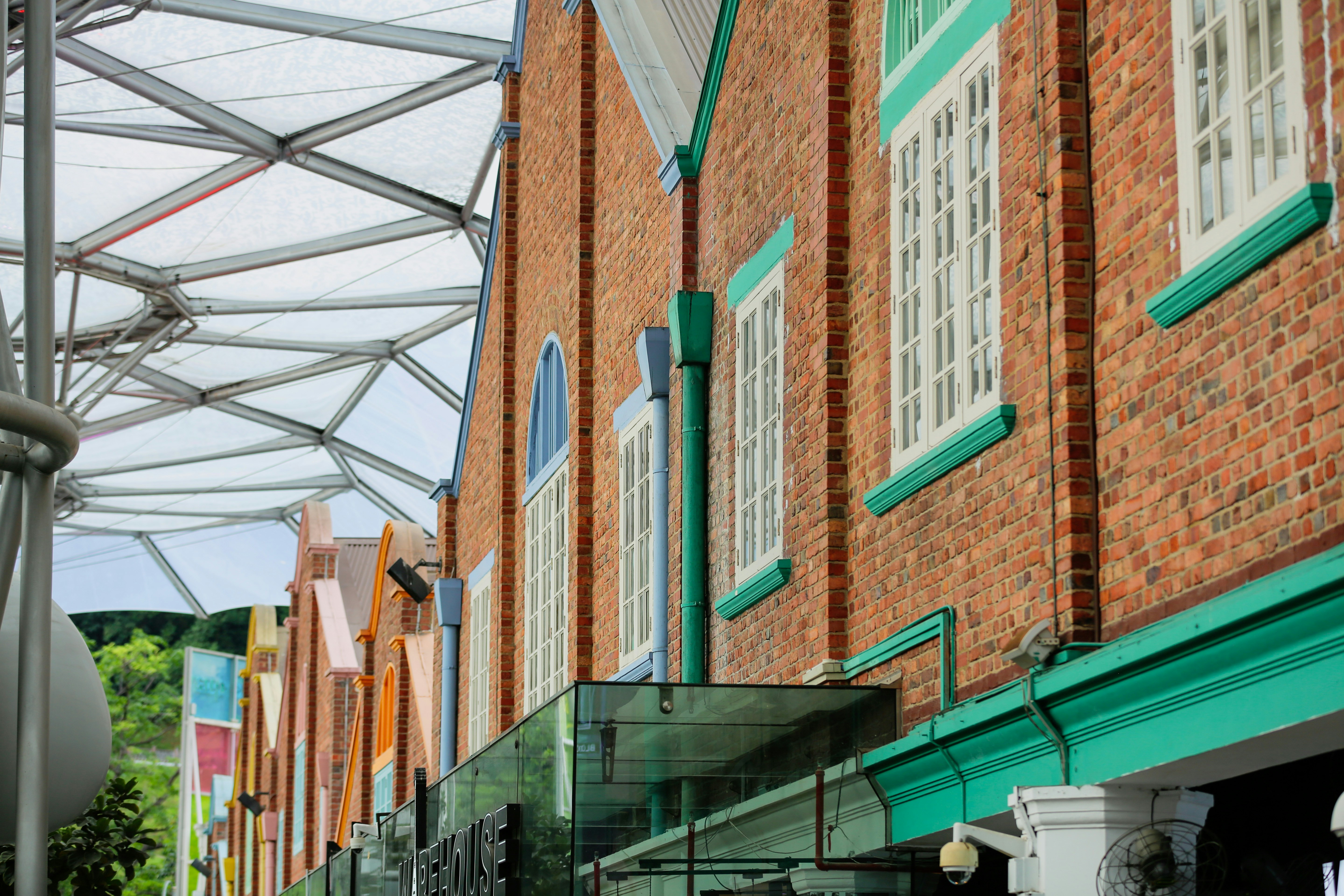 Colorful brick buildings lined beneath a modern canopy, showcasing a blend of historical architecture and contemporary design.