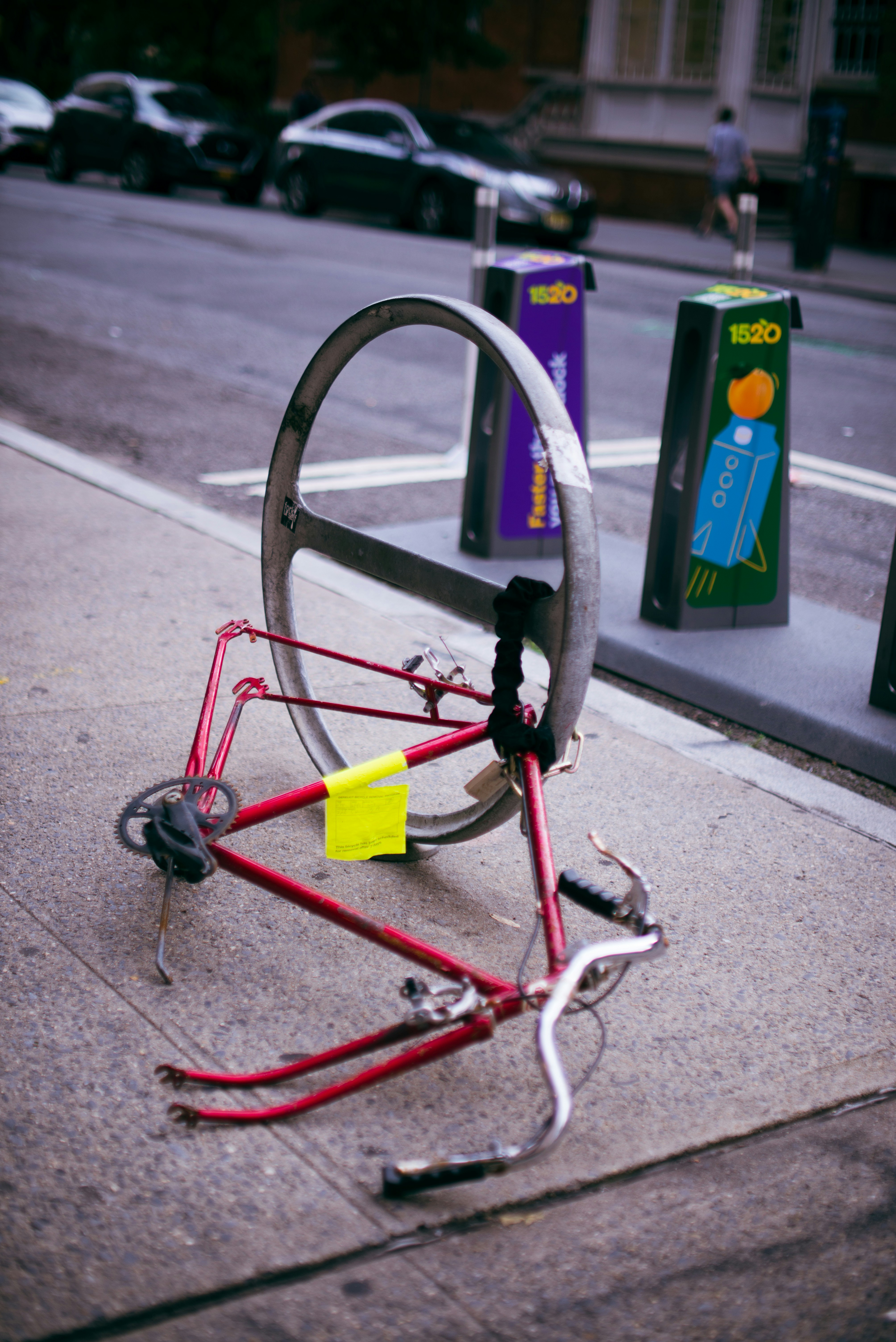 Urban Relic: A Red Bicycle Entangled with a Steel Ring on the Sidewalk
