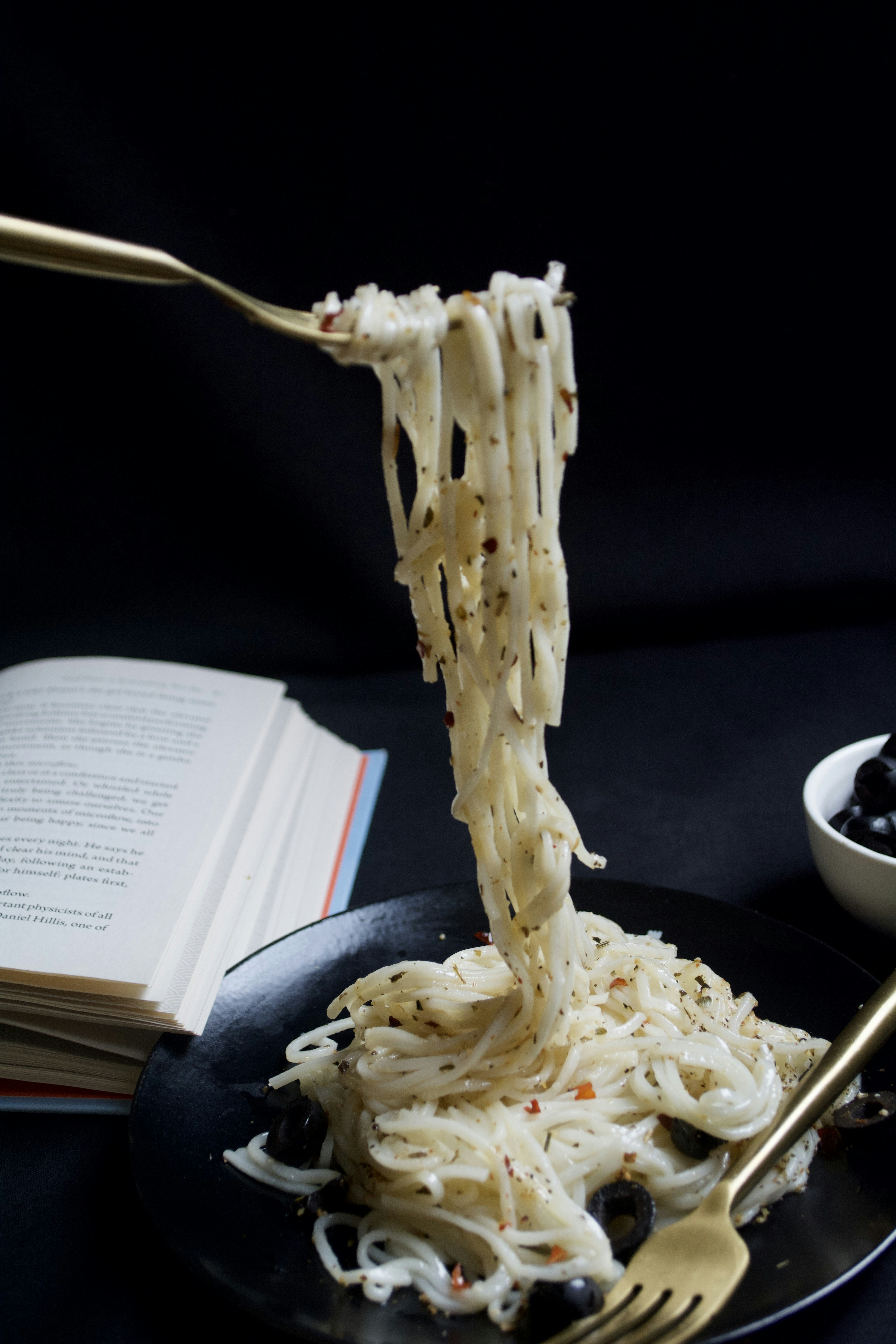 Midnight Strings: Spaghetti Lift on a Fork Over a Shadowed Plate