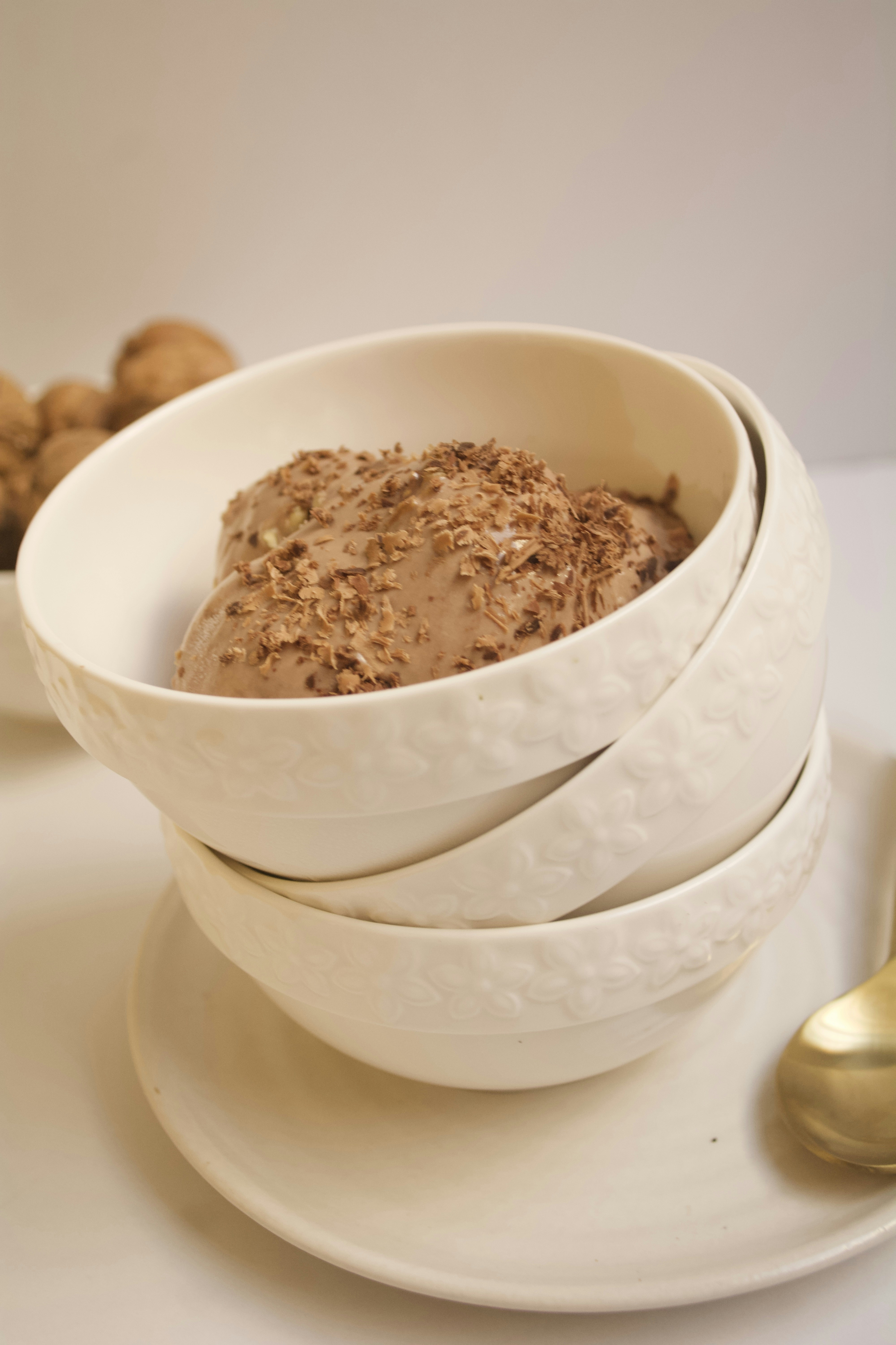 Stacked Porcelain Bowls Cradle a Cocoa-Dusted Ice Cream Scoop