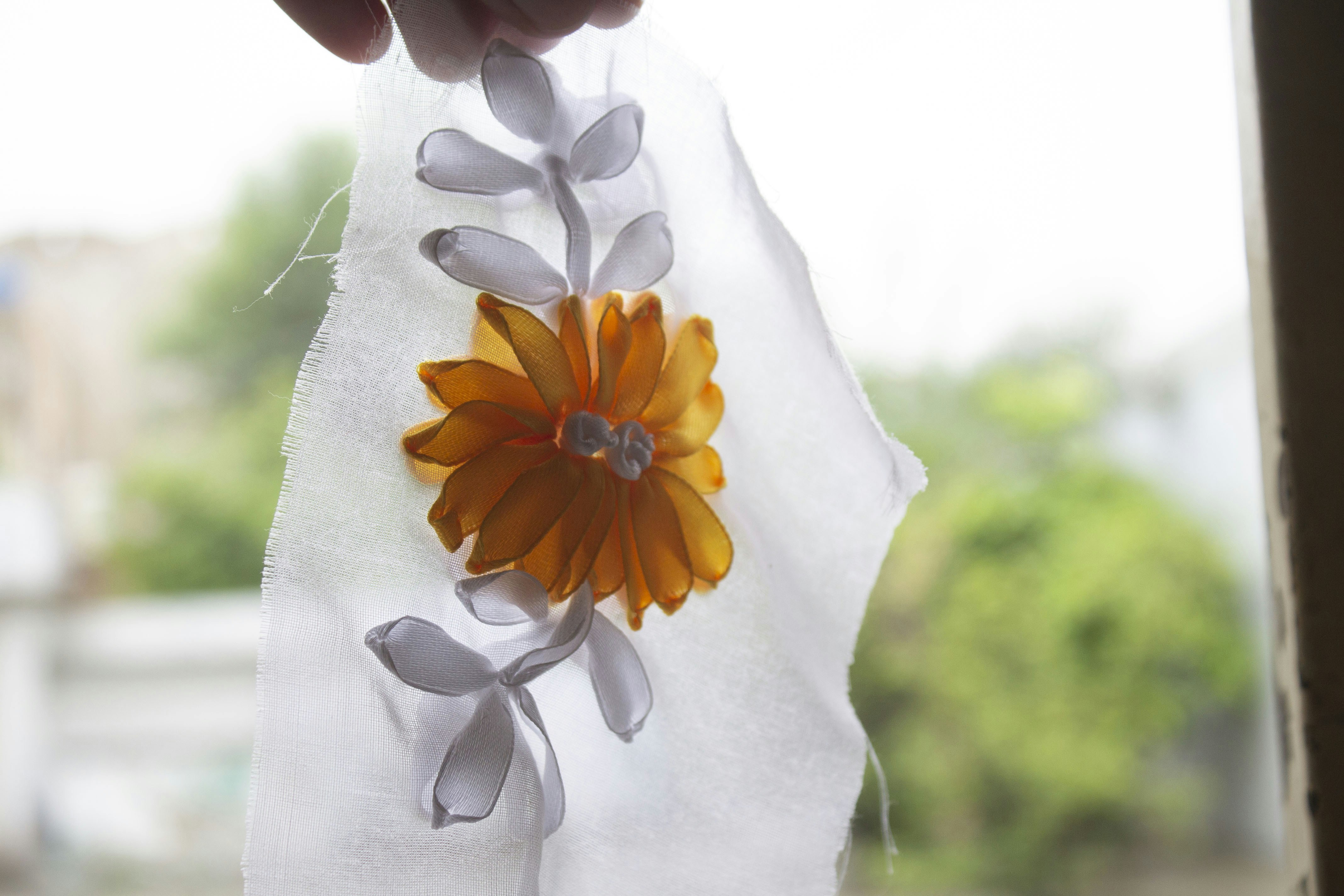 white and orange flower on white textile