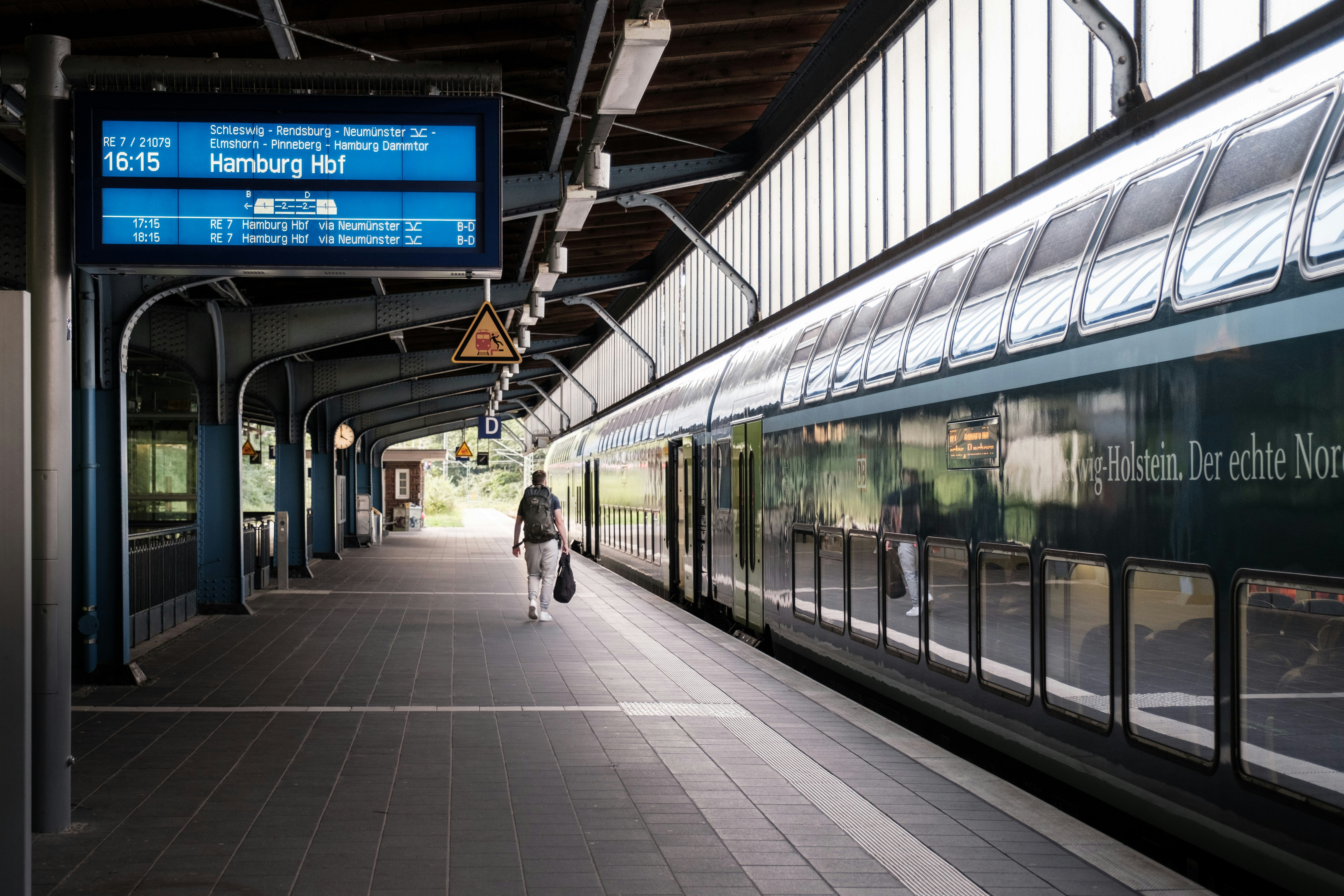 Mann in schwarzer Jacke beim Spaziergang auf dem Bahnhof Foto ...