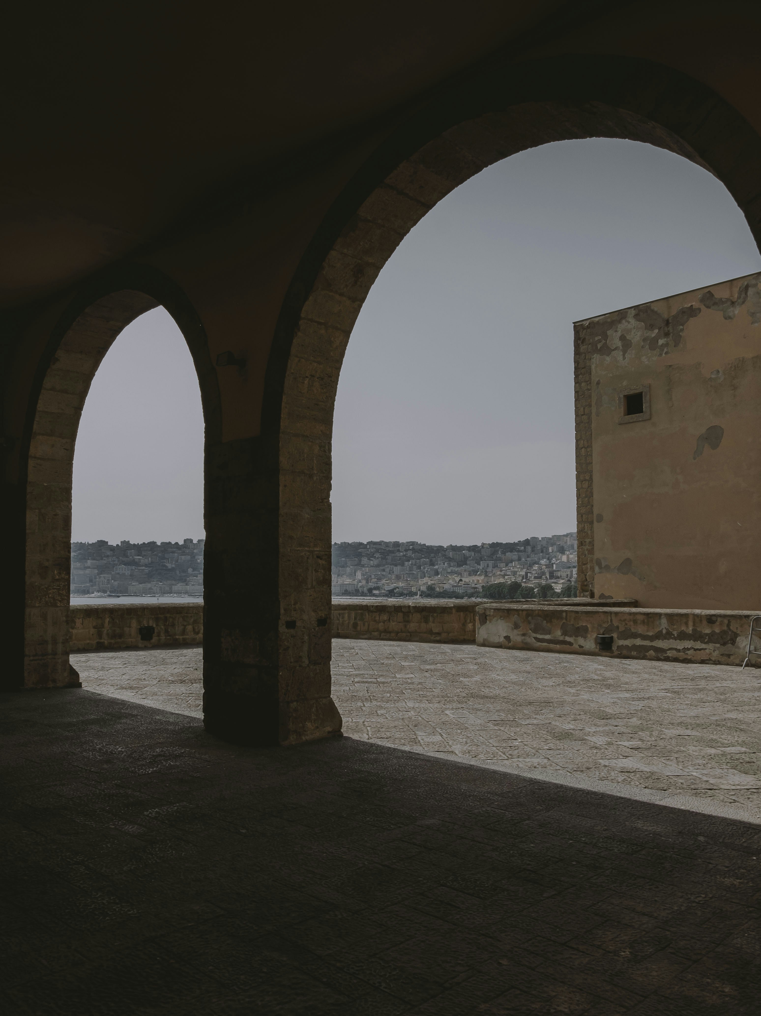 Arches at Distant Light: A Coastal Vista Framed by Time-Worn Stone
