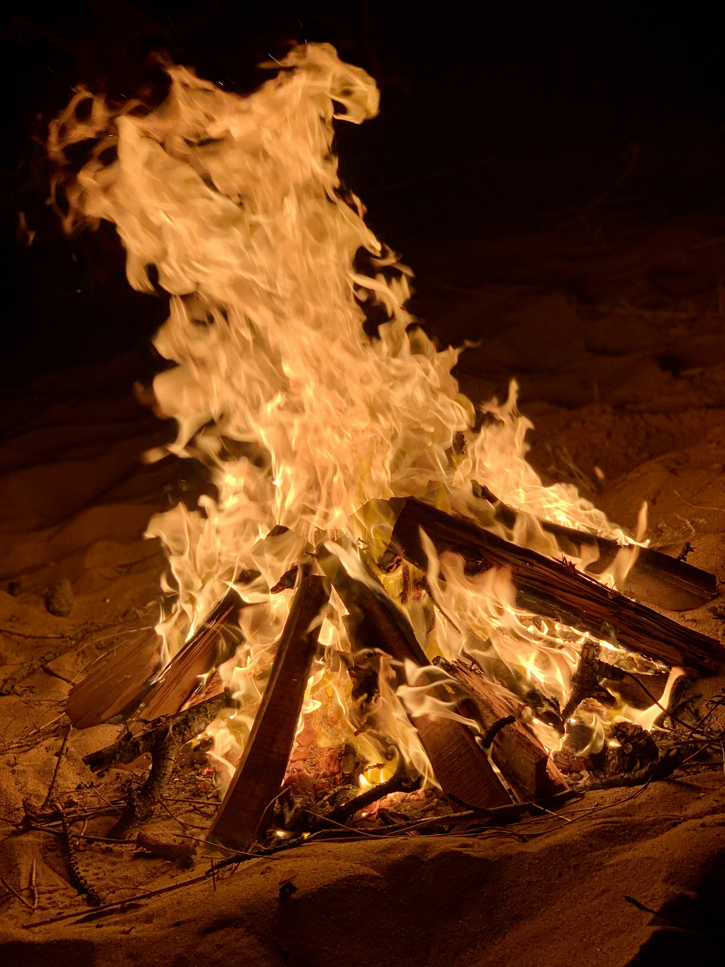 Embers on Sand: A Solitary Campfire Illuminates a Desert Night