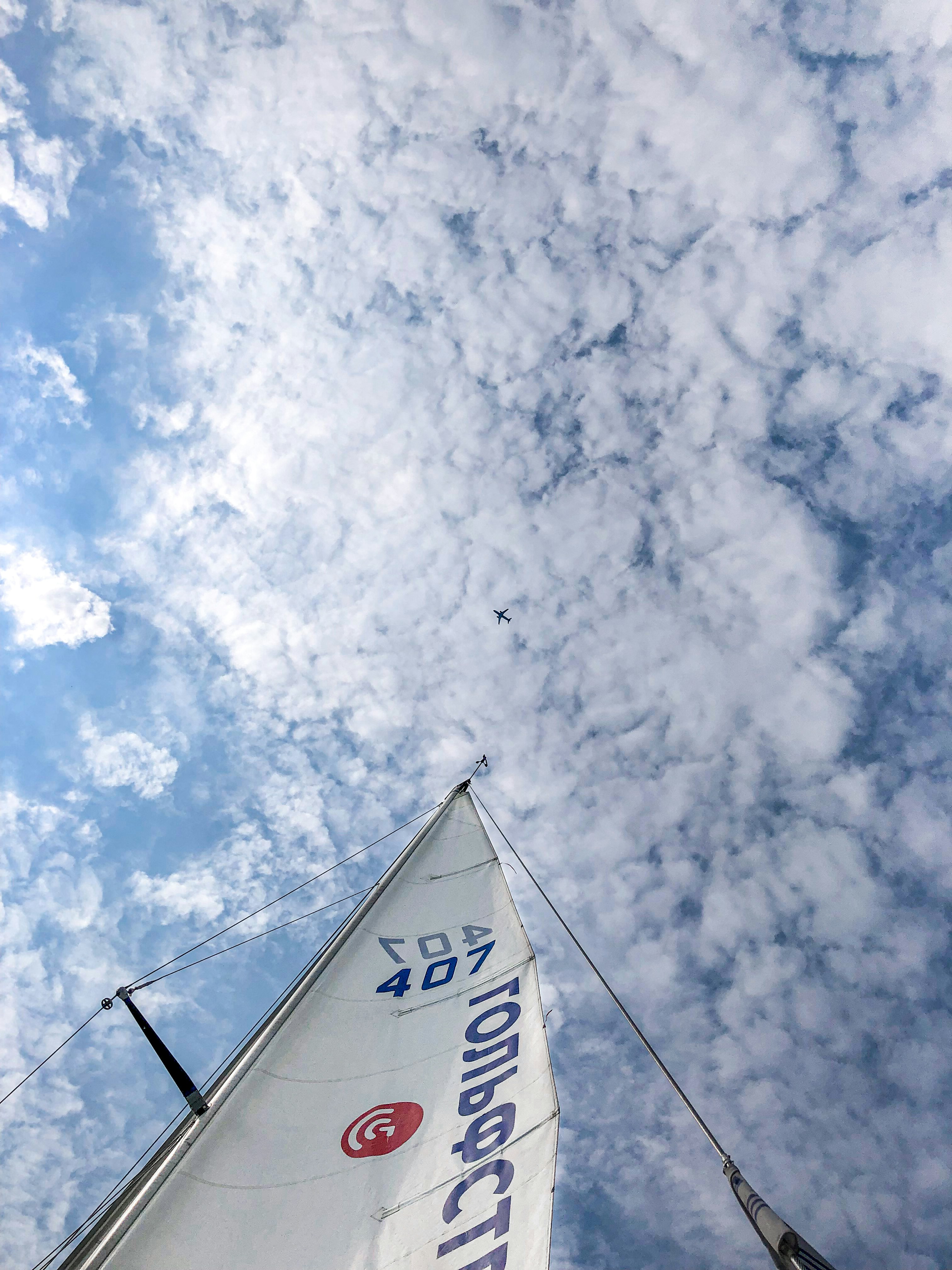 Toward the Sky: A Low-Angle Sail Against a Patchwork Sky