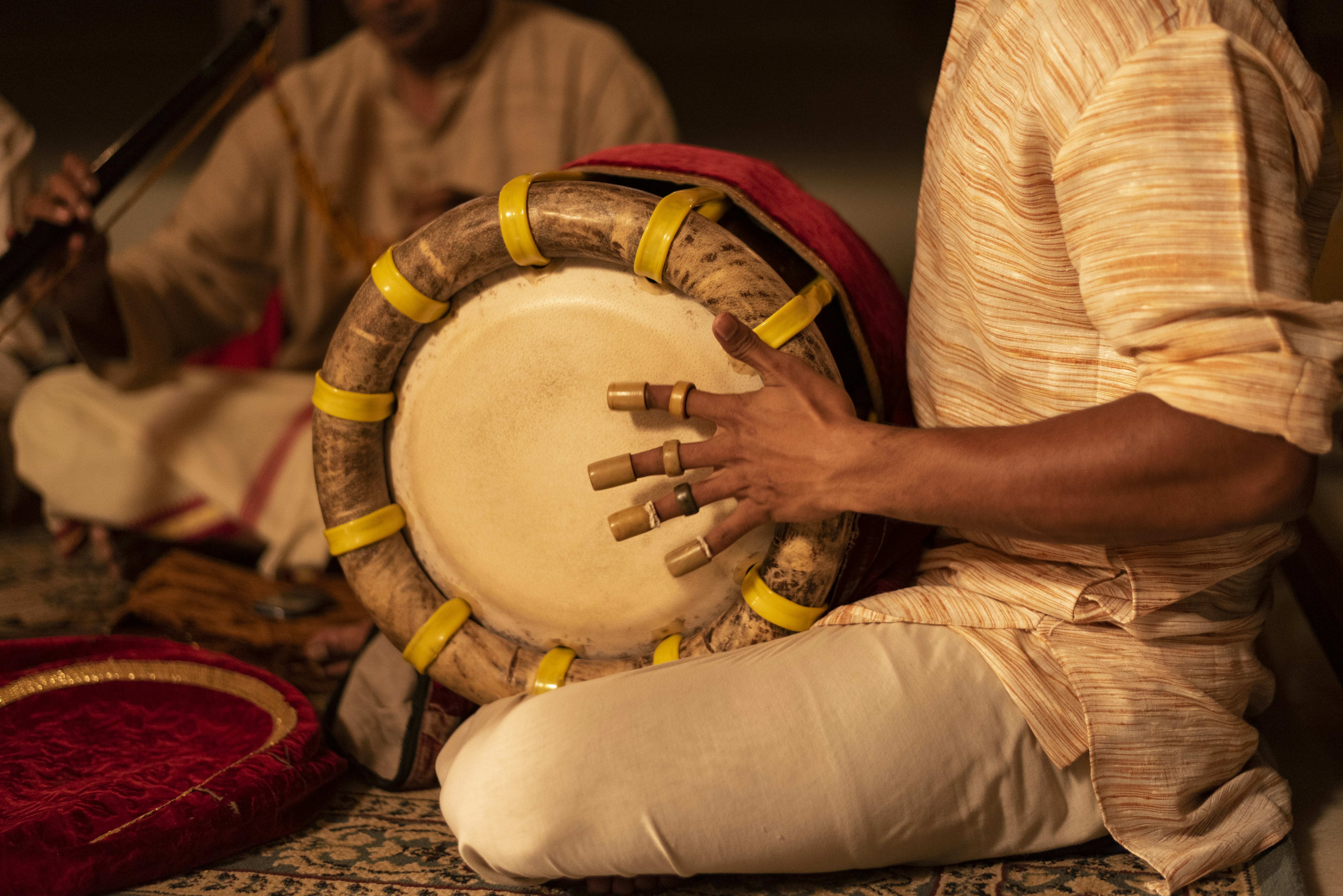 Musician playing a Thavil drum during a traditional Indian wedding ceremony.