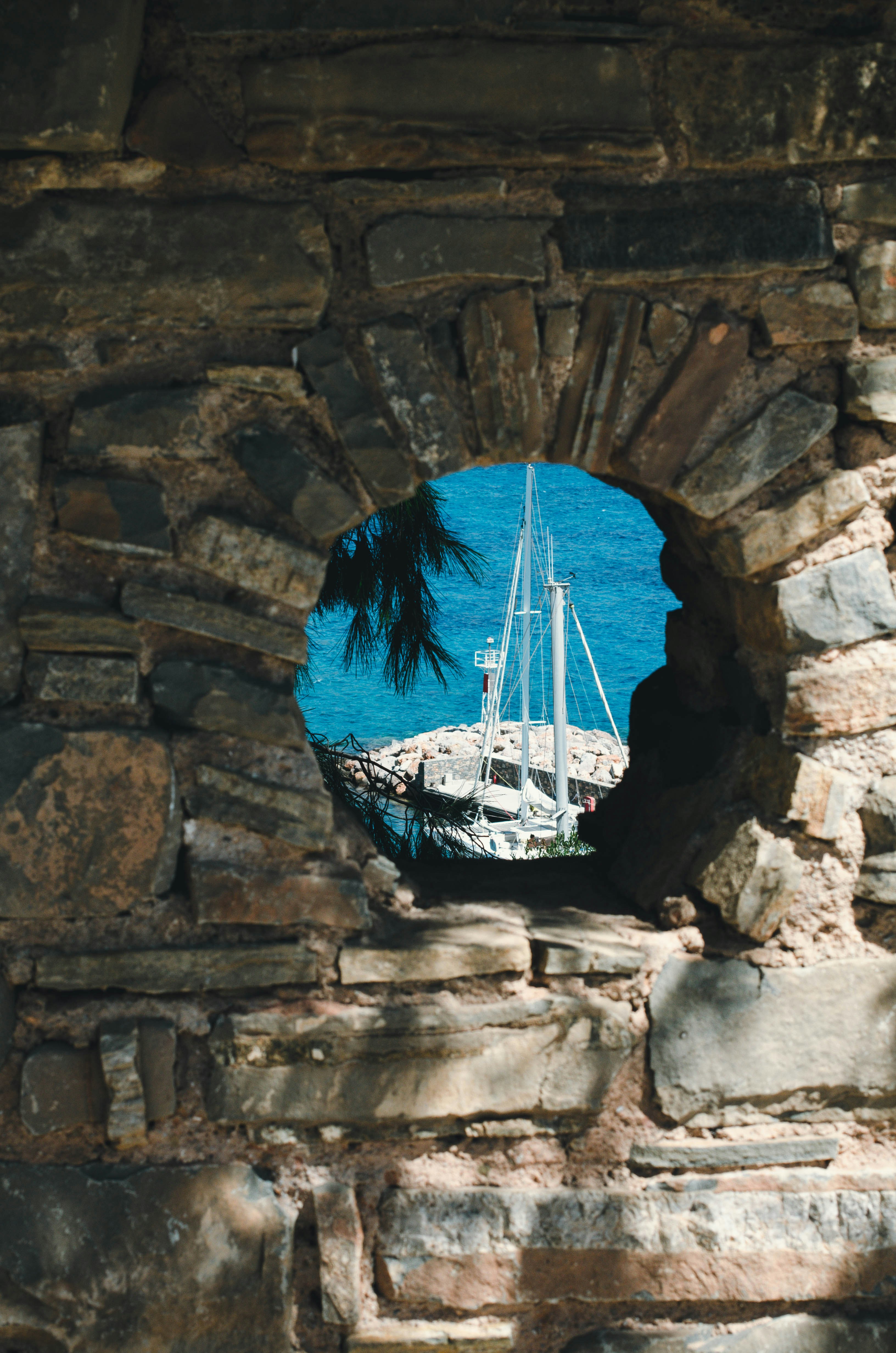 white sail boat on brown rock formation during daytime