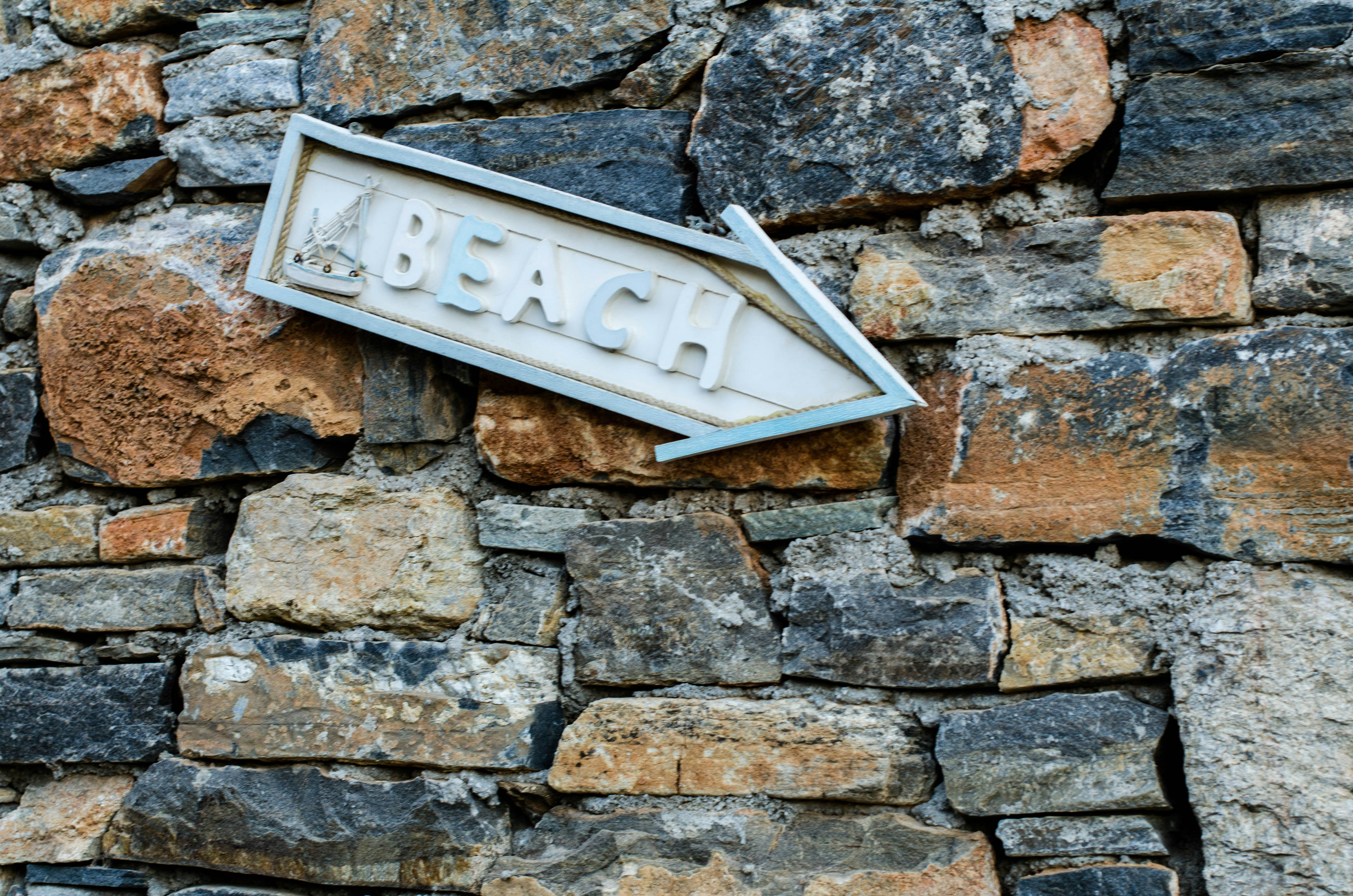 Arched Stone Wall and Weathered Beach Sign