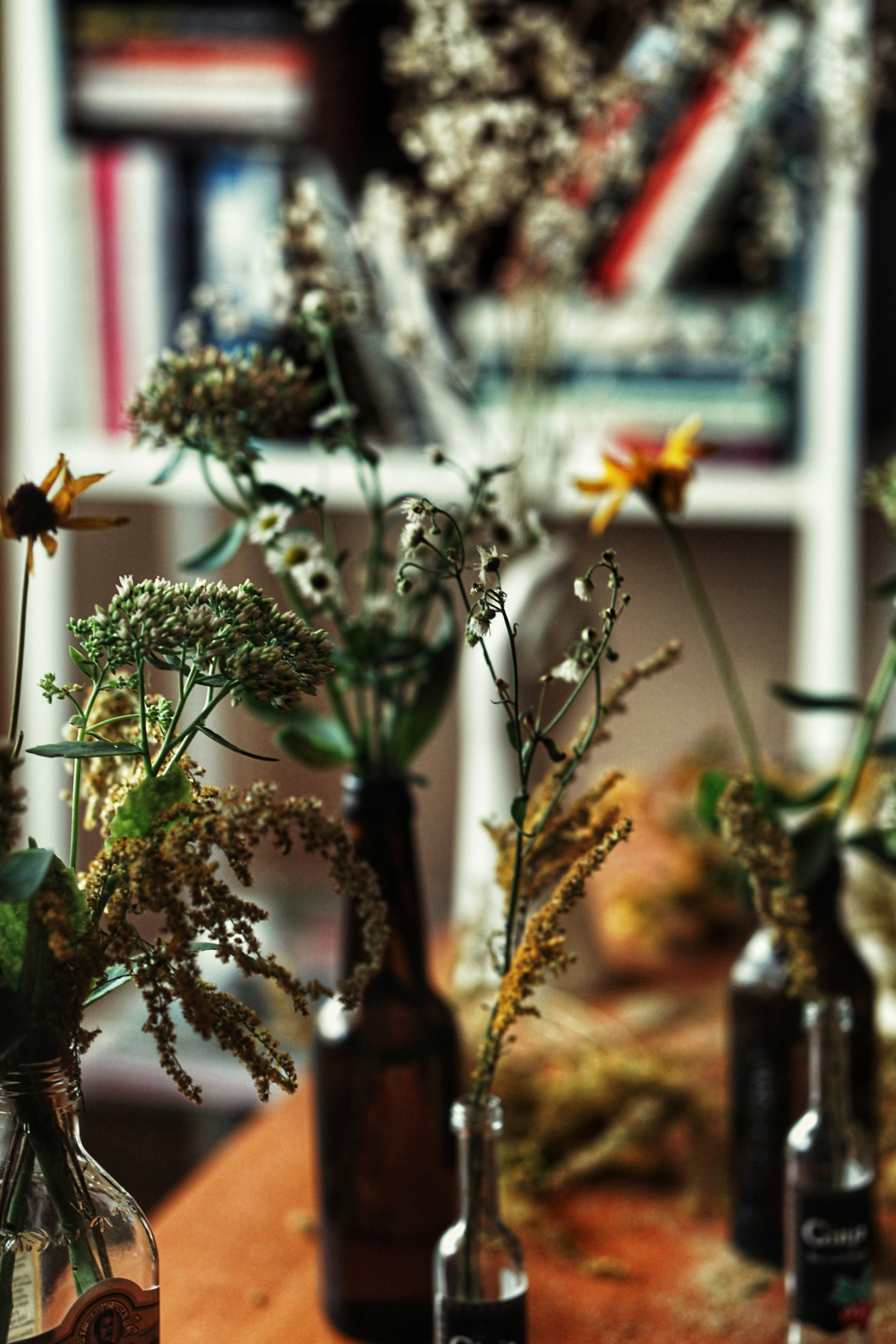 Amber Bottles and Wildflowers: A Quiet Still-Life by a Bookshelf