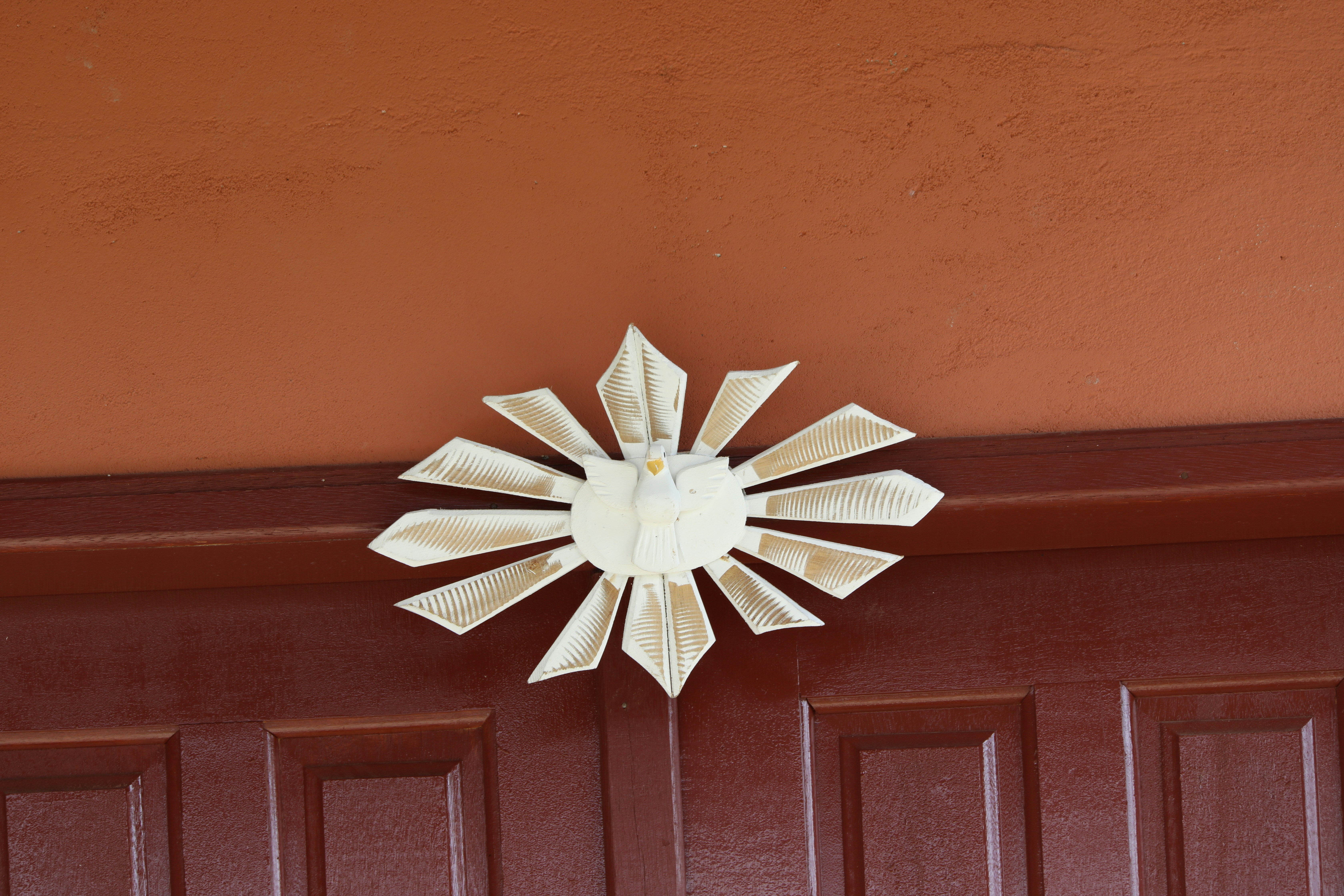 White Sunburst Ornament Anchored to a Rustic Door