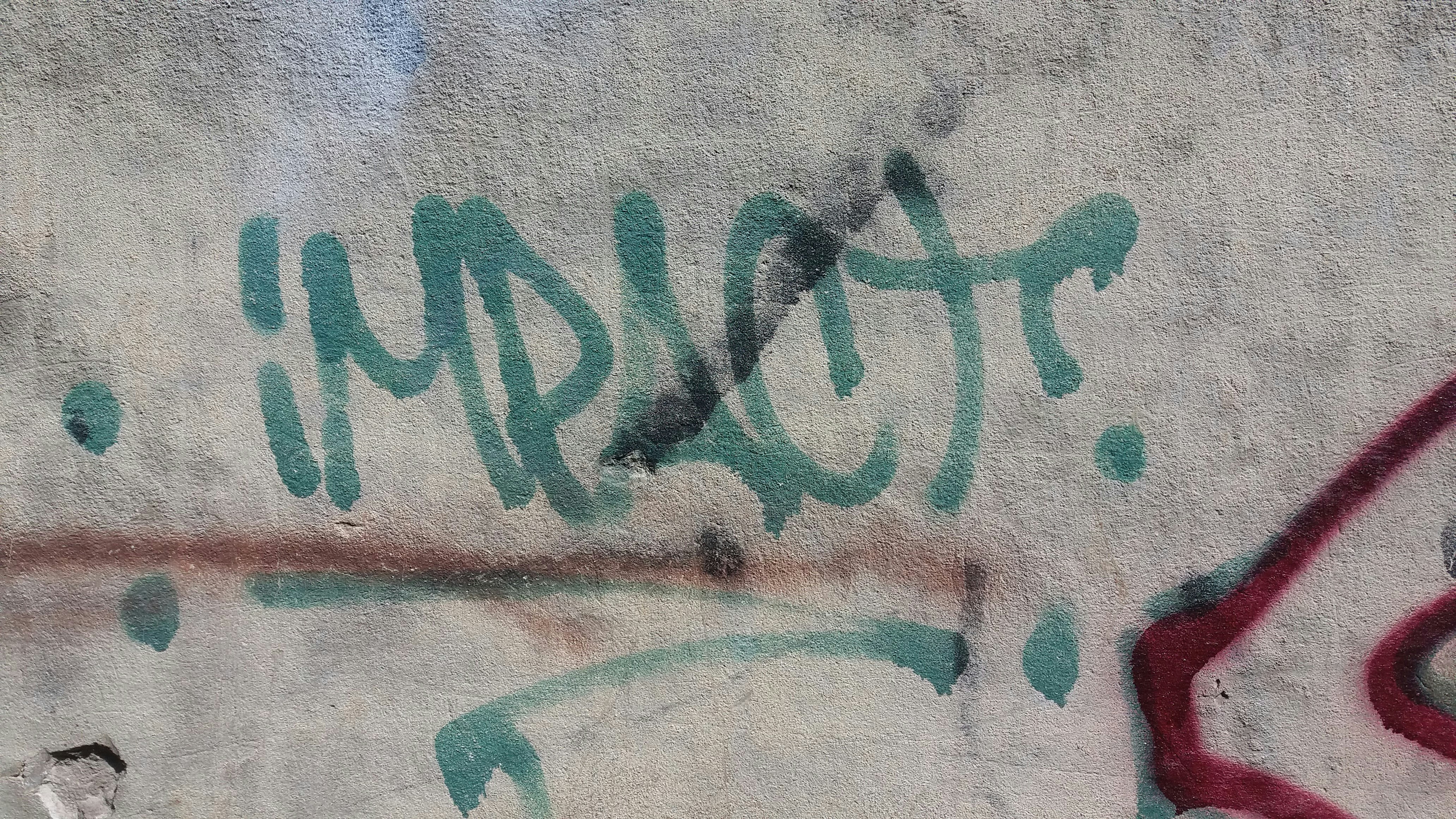 Teal Graffiti Script on Weathered Concrete