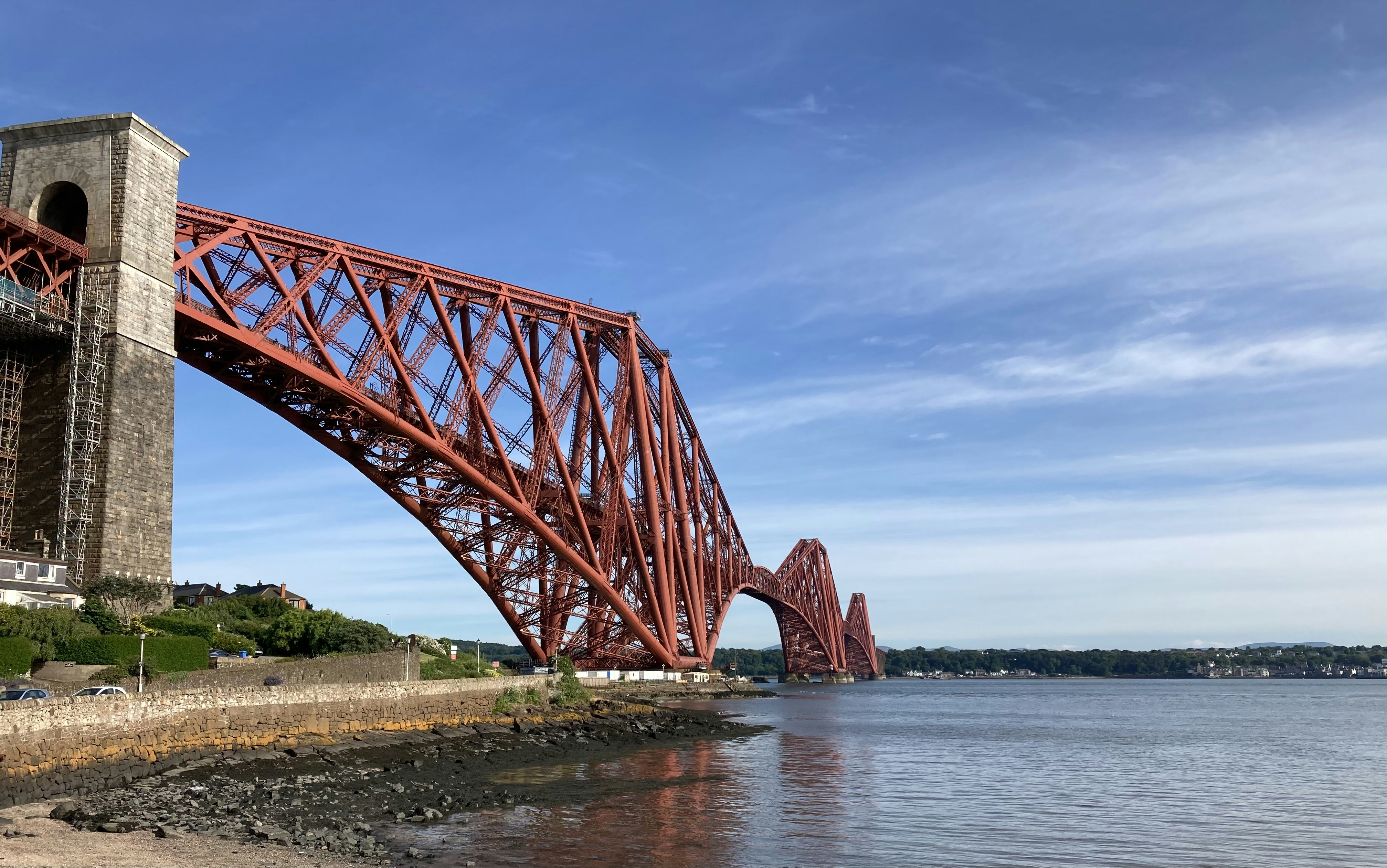 Red metal bridge over the river under blue sky during daytime photo ...