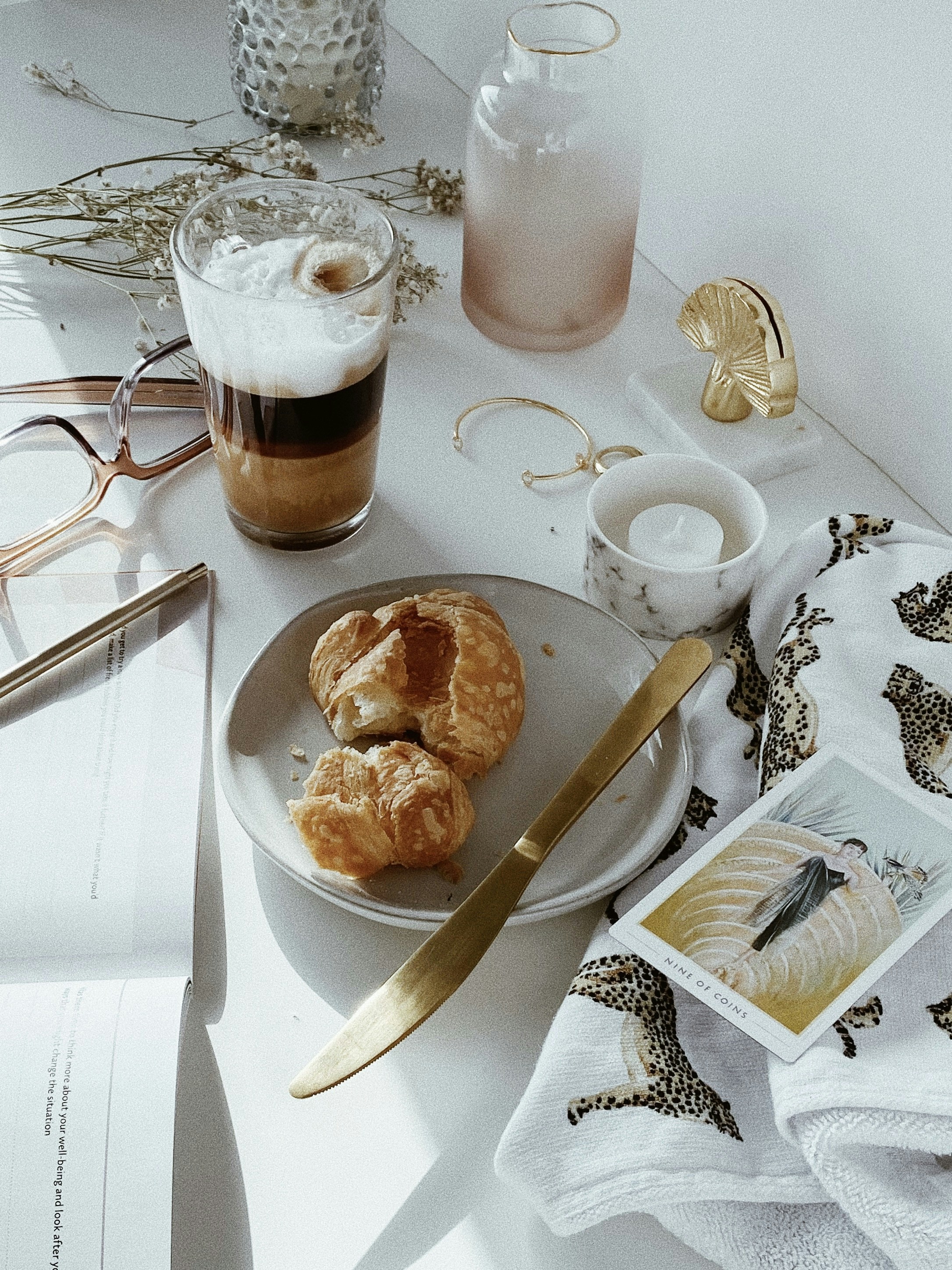 Morning Light Still Life: Croissants, Coffee, and Delicate Accessories on a Minimal Desk