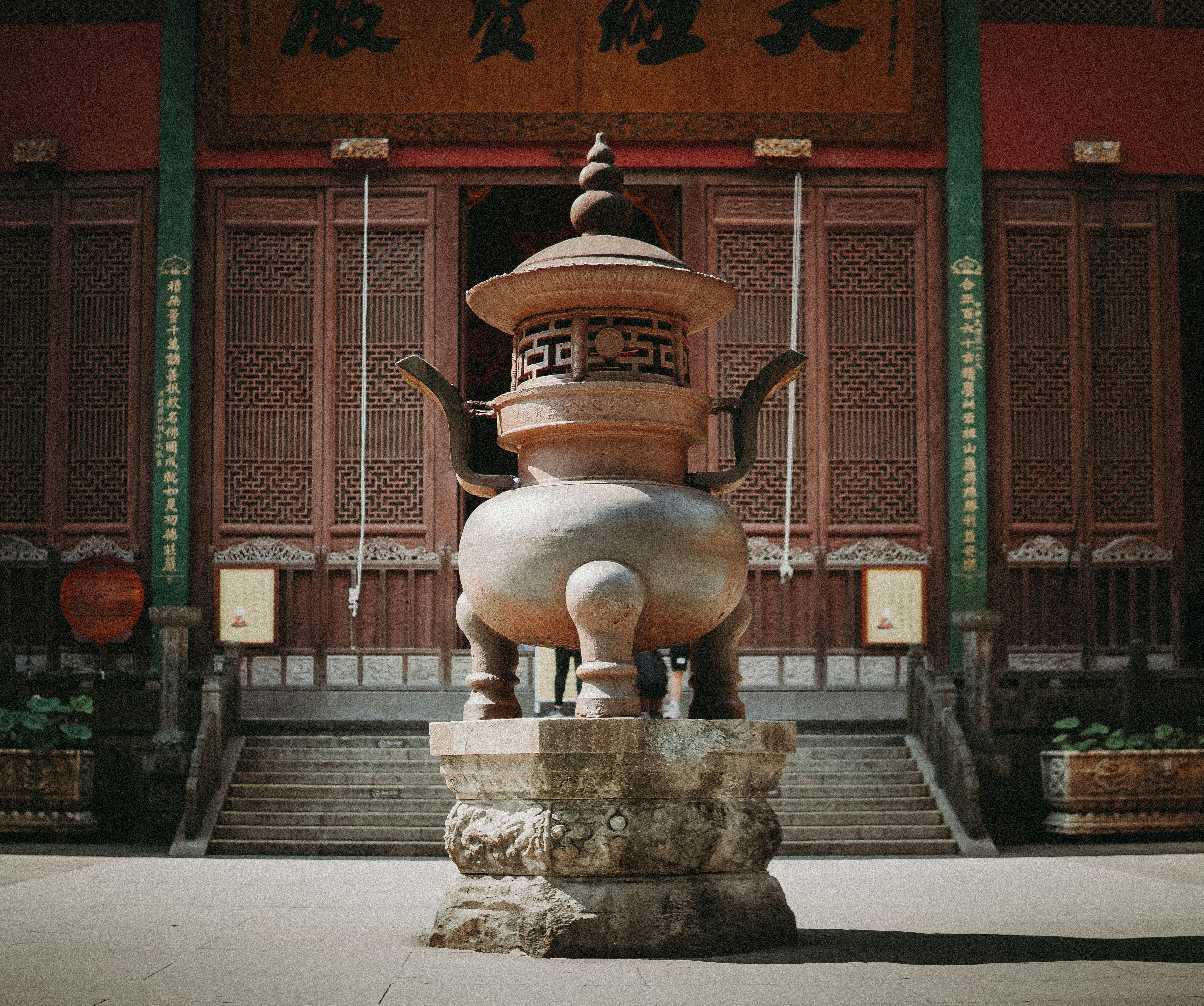 Brown concrete statue near red building during daytime photo – Free ...