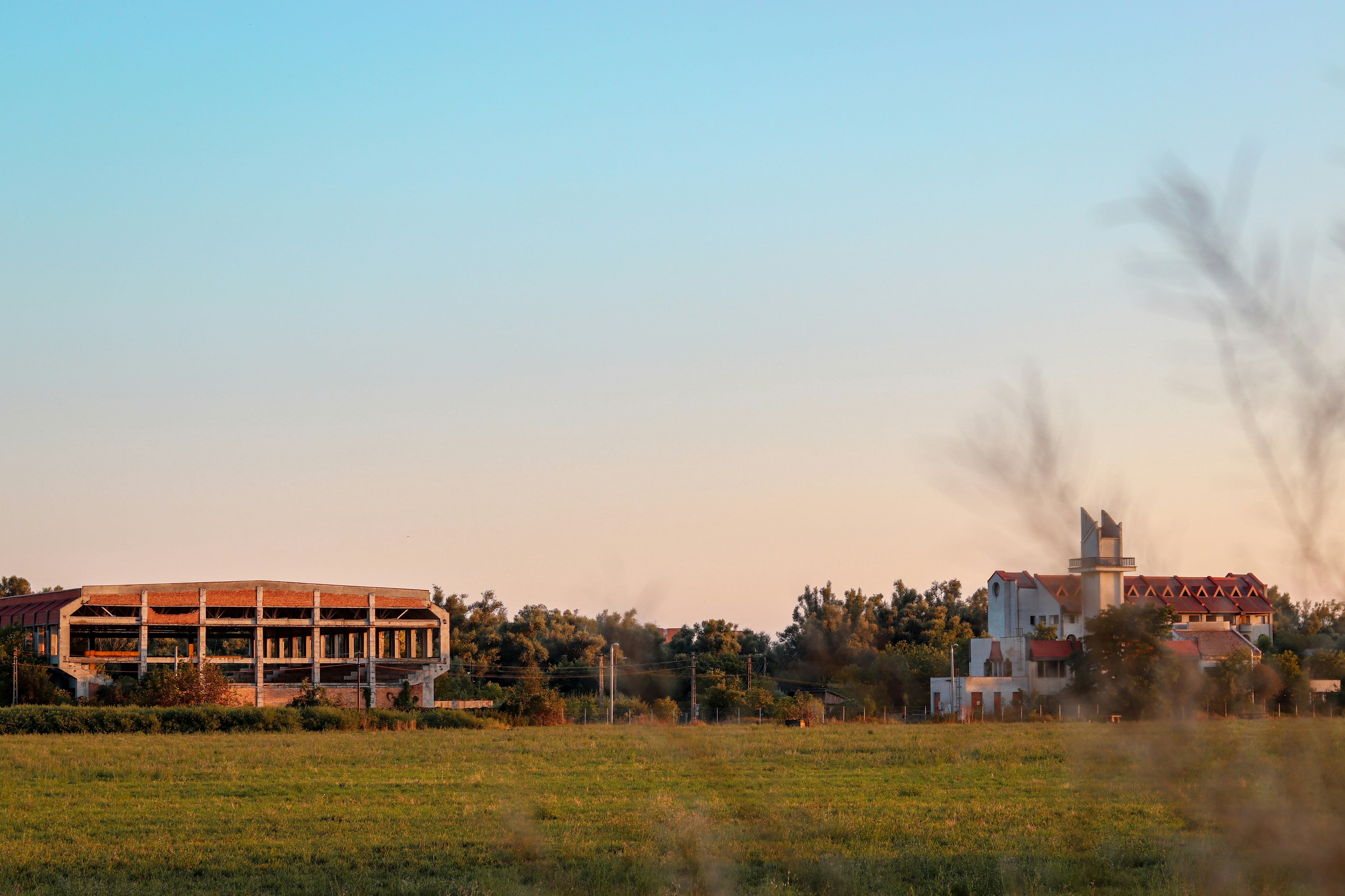 Distant view of a stadium and traditional building against a clear evening sky.