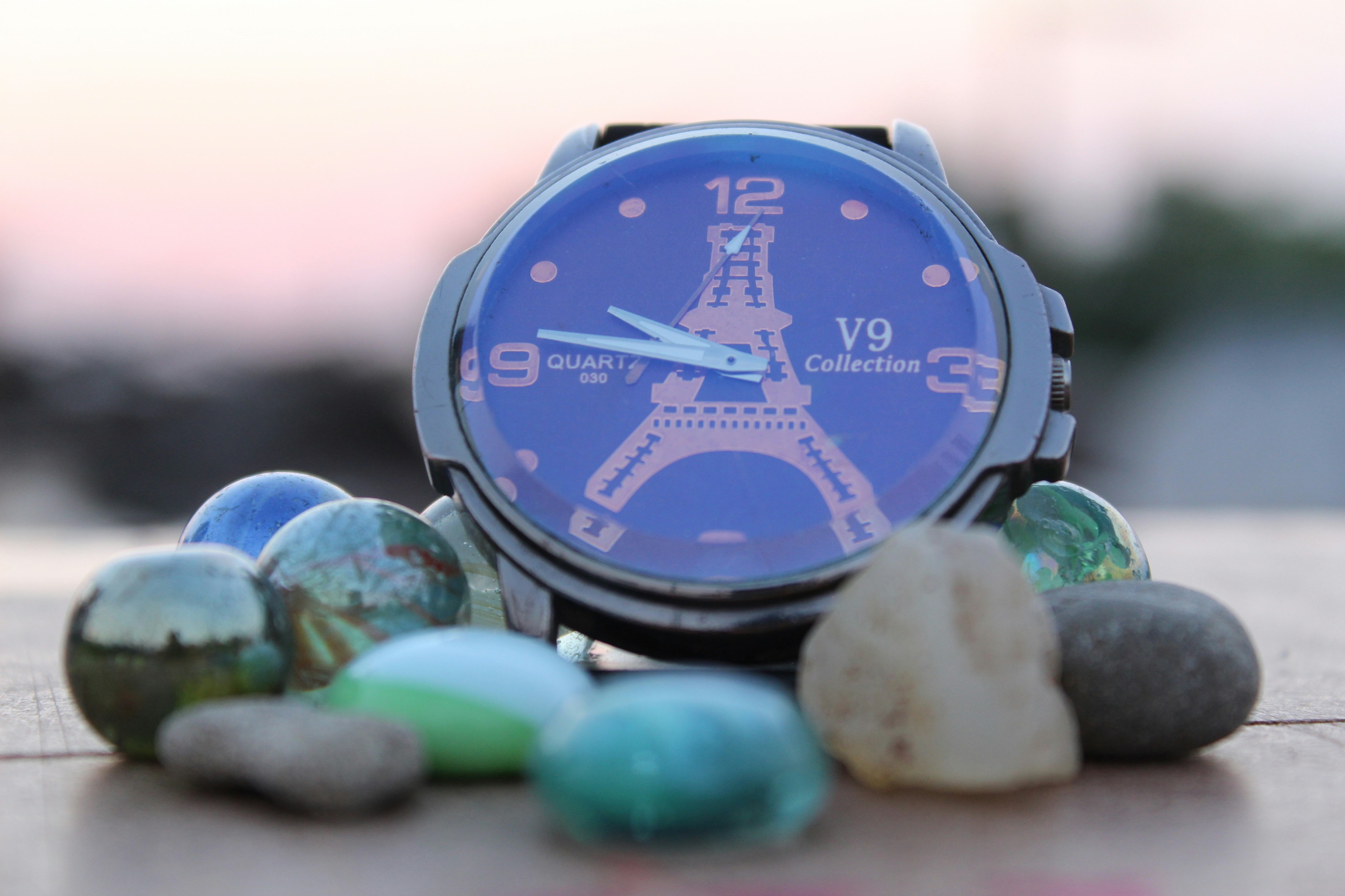 Blue Eiffel Dial Amid Pebbles: A Quiet Timepiece Portrait