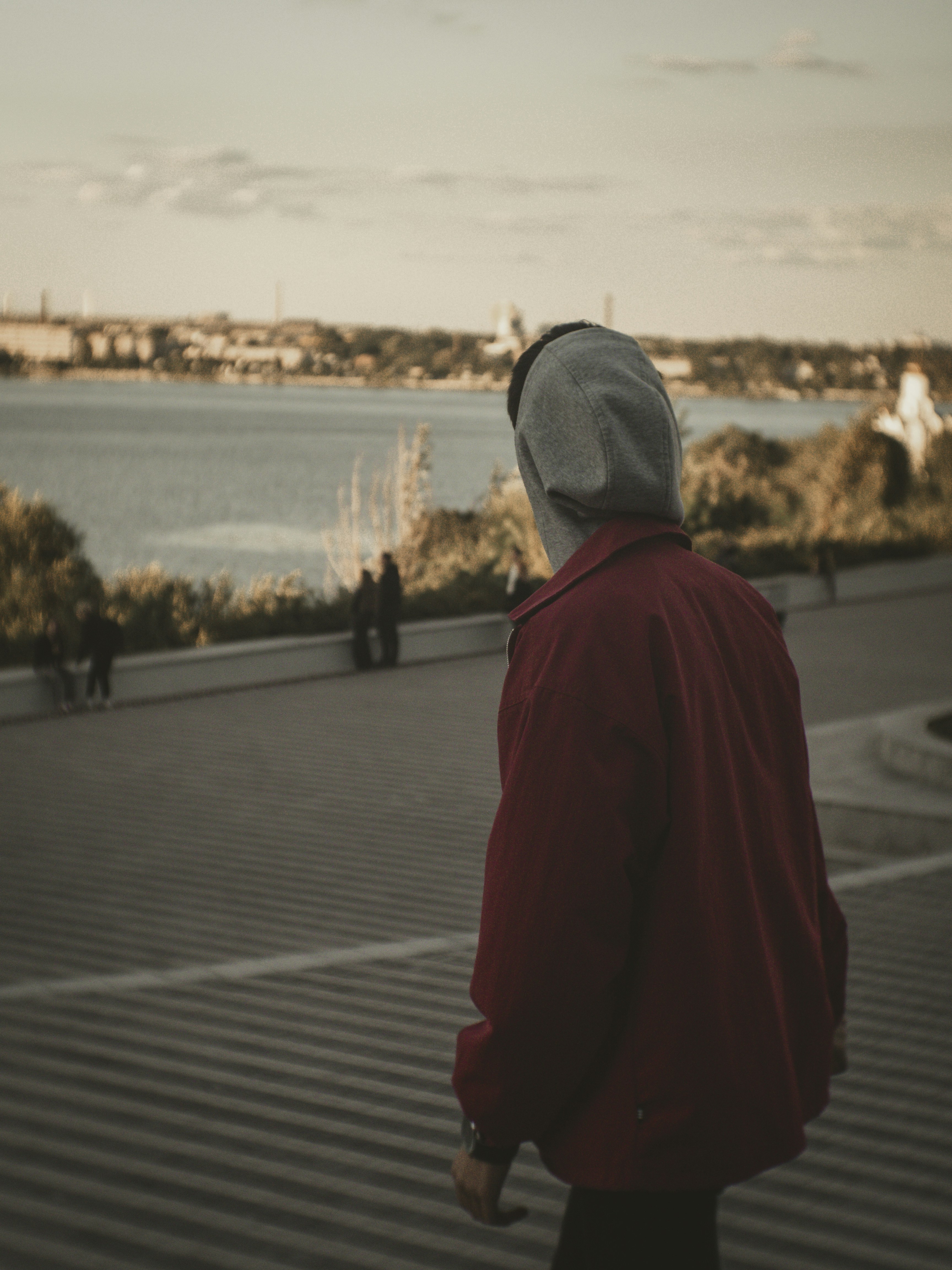 Foto de persona con capucha roja parada en un piso de concreto gris ...