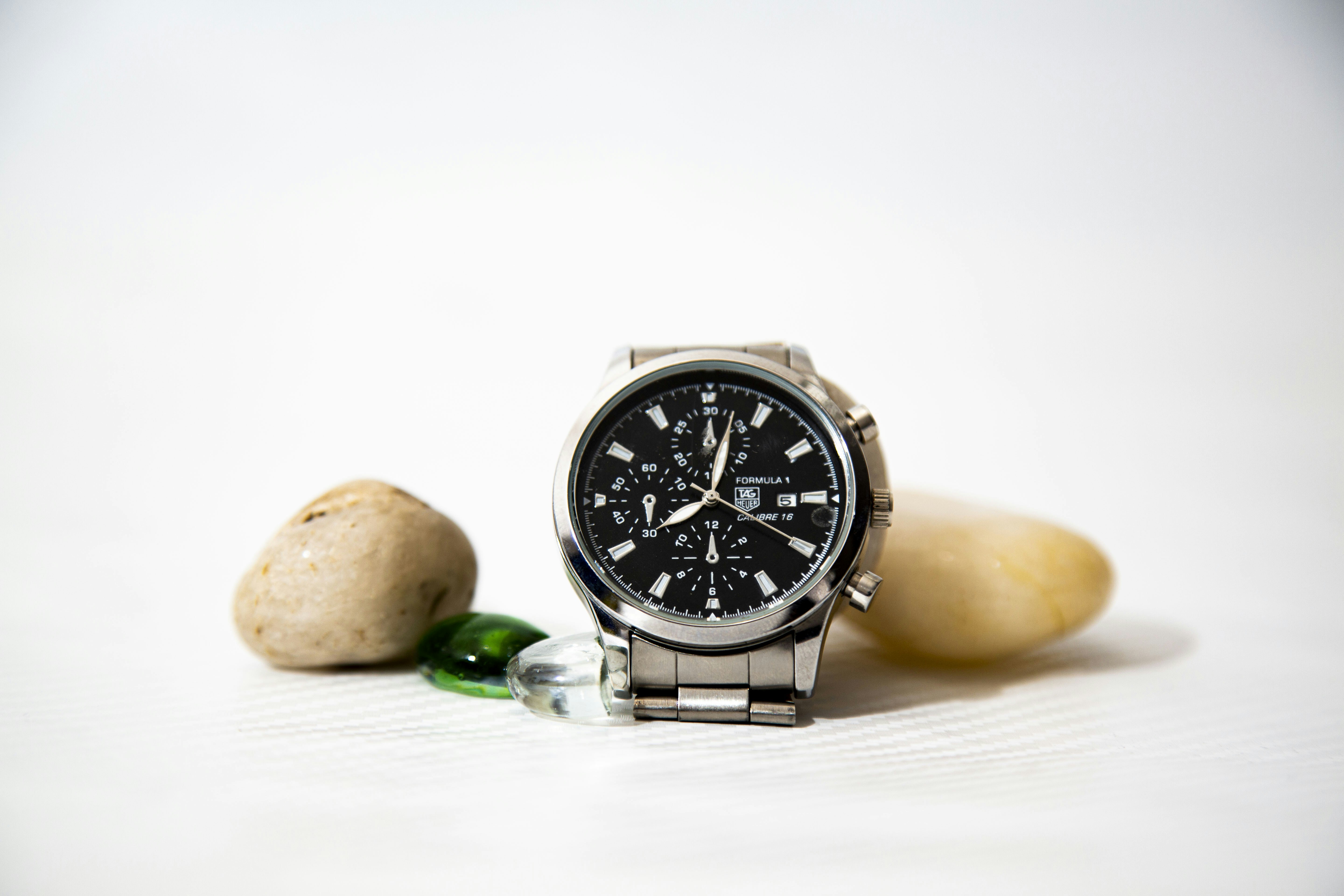 Quiet Precision: A Wristwatch Amid Pebbles and Glass