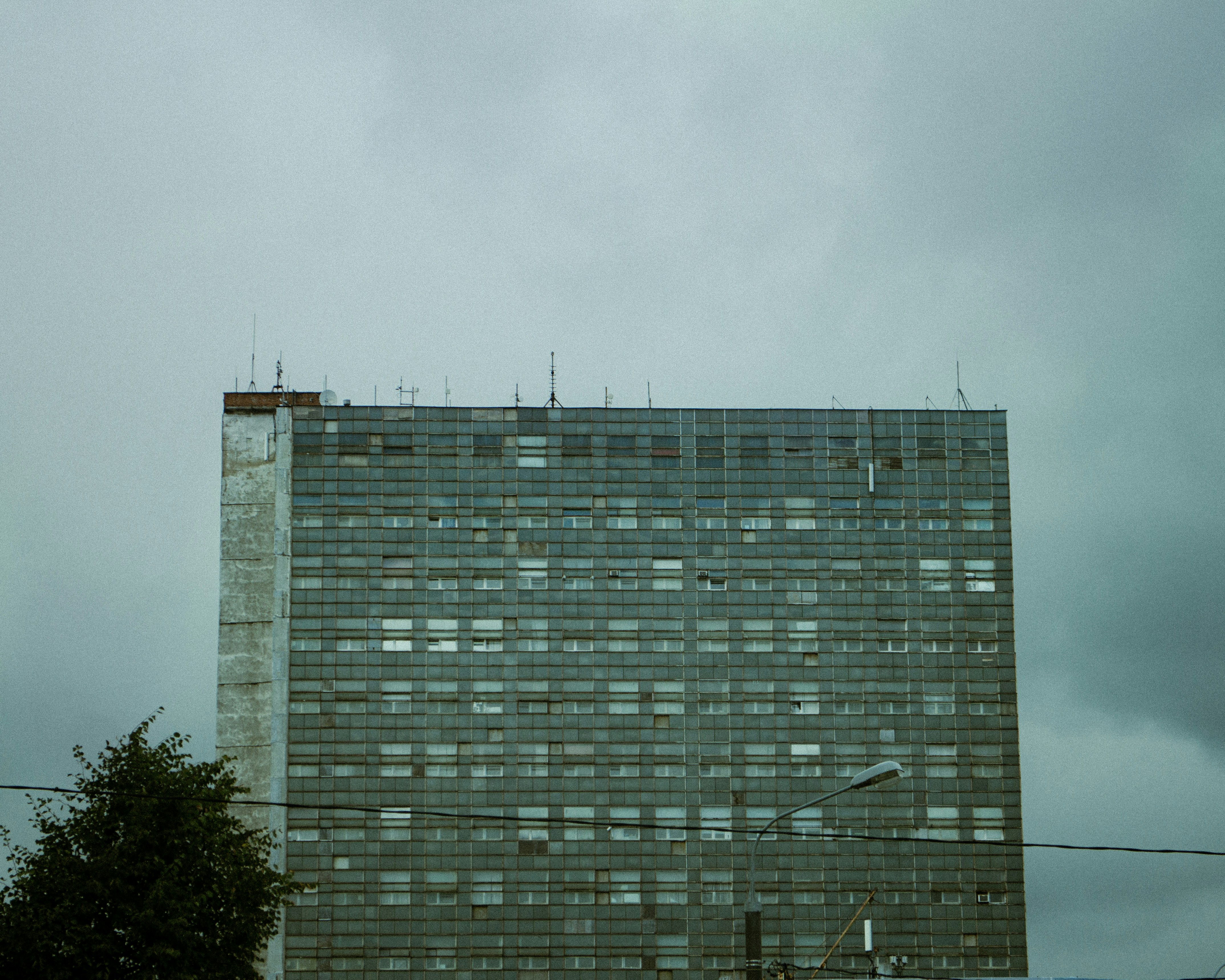 Monolithic Grid Under Gray Skies: The Facade of a Tall High-Rise