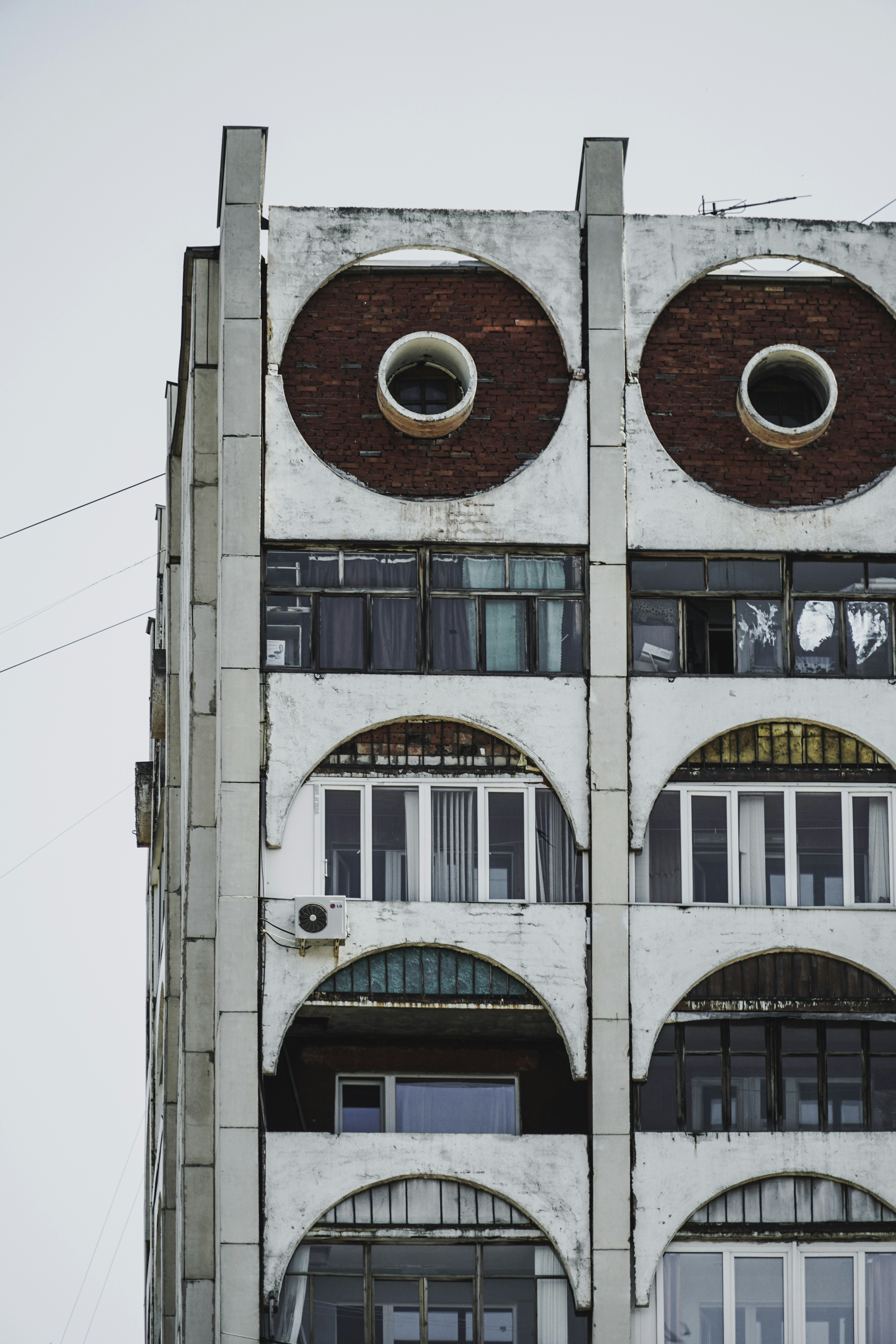 Twin Circular Windows Crown a Weathered Concrete Facade