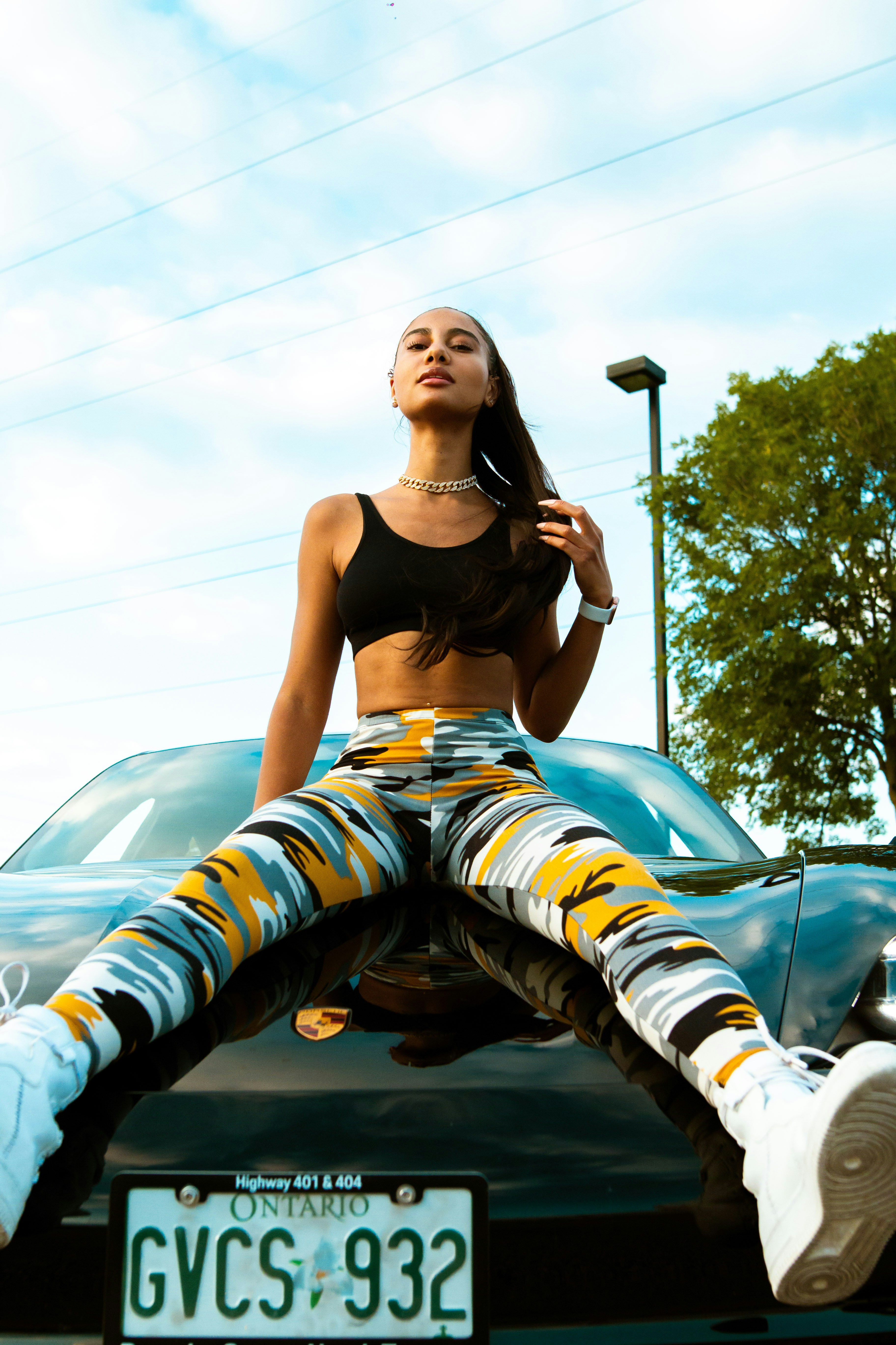 Confidence on Chrome: A bold pose atop a sports car under a bright sky