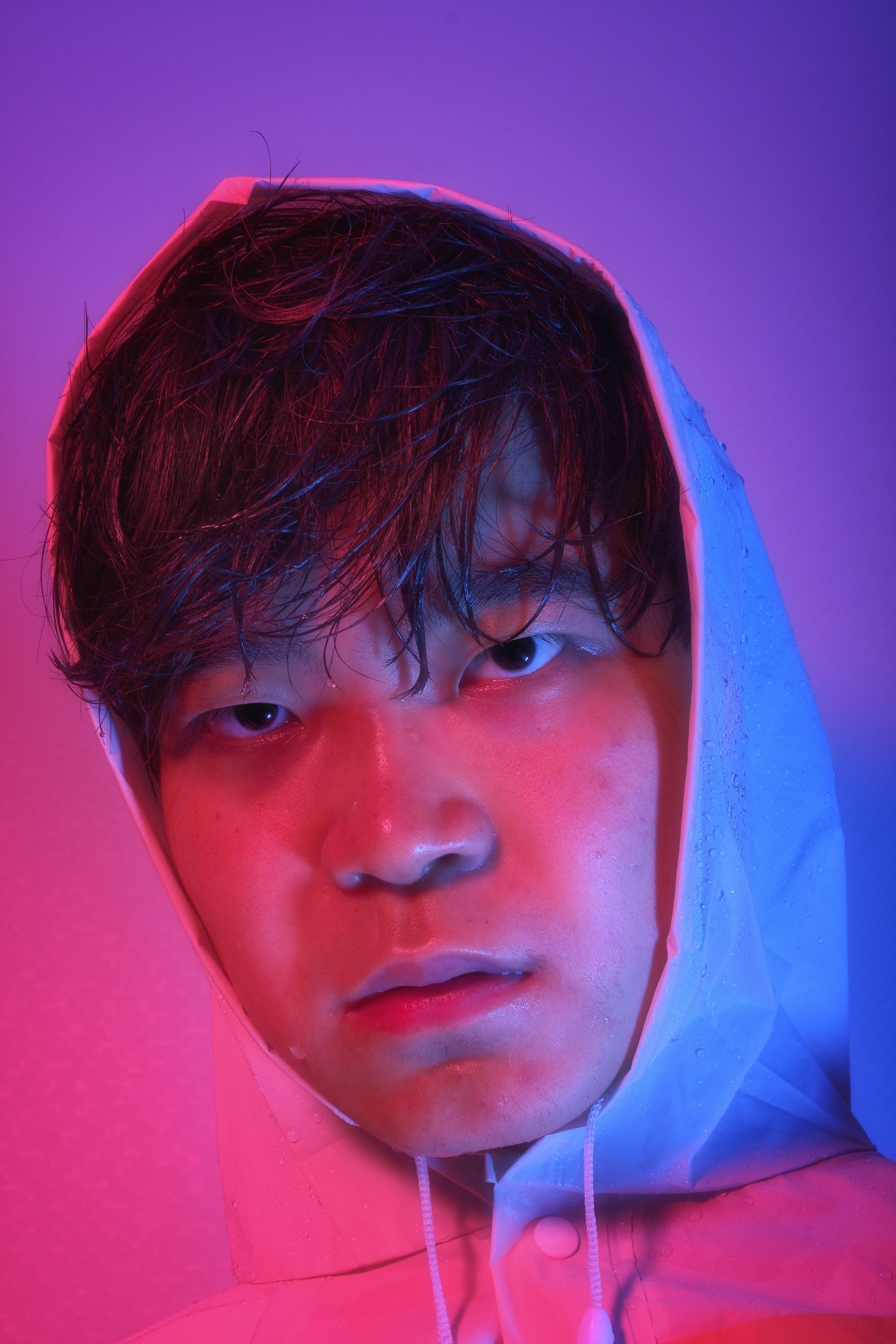 Crimson and Cyan Neon Gaze Under a Hoodie