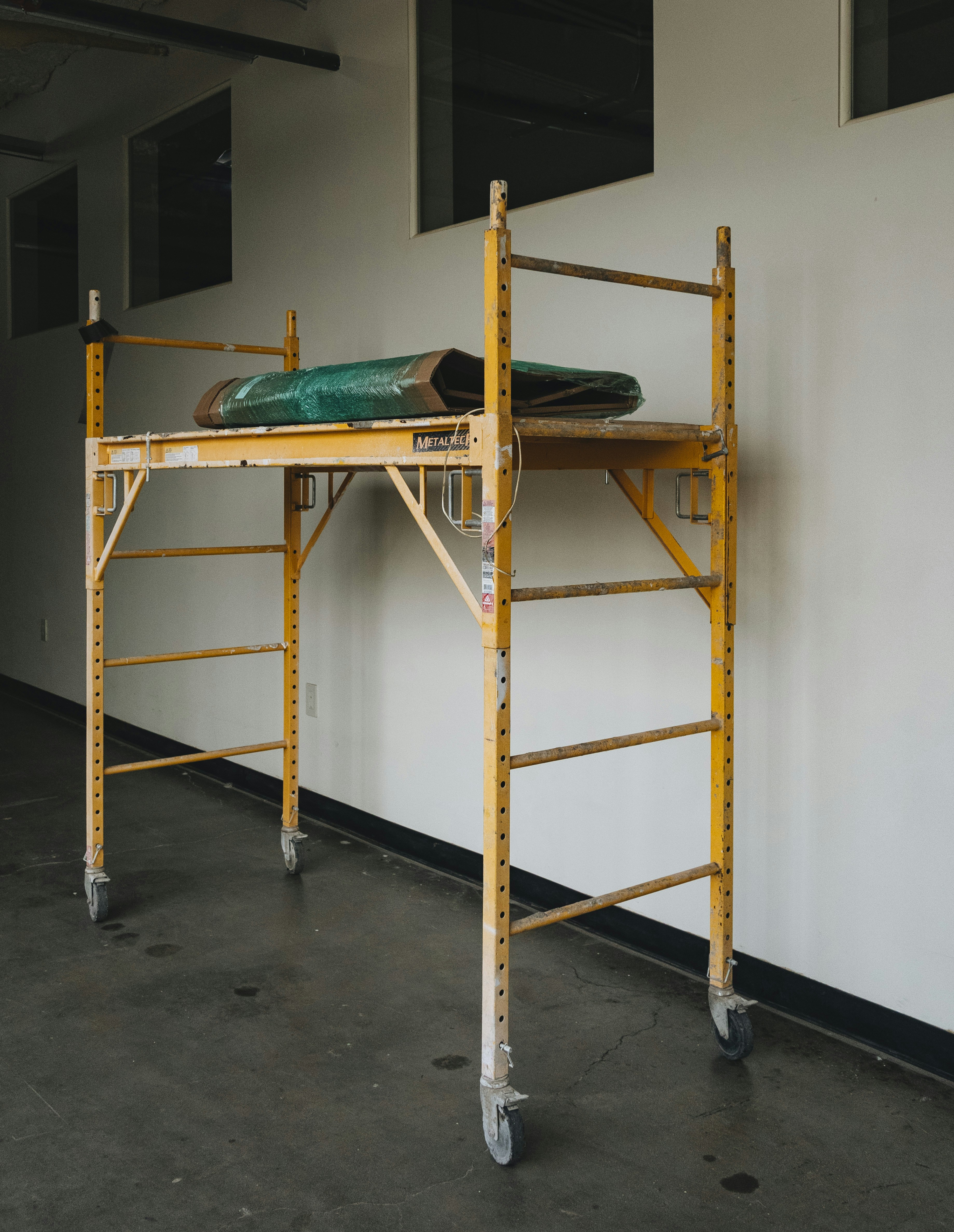 Yellow Mobile Scaffold Tower in a Minimalist Workshop