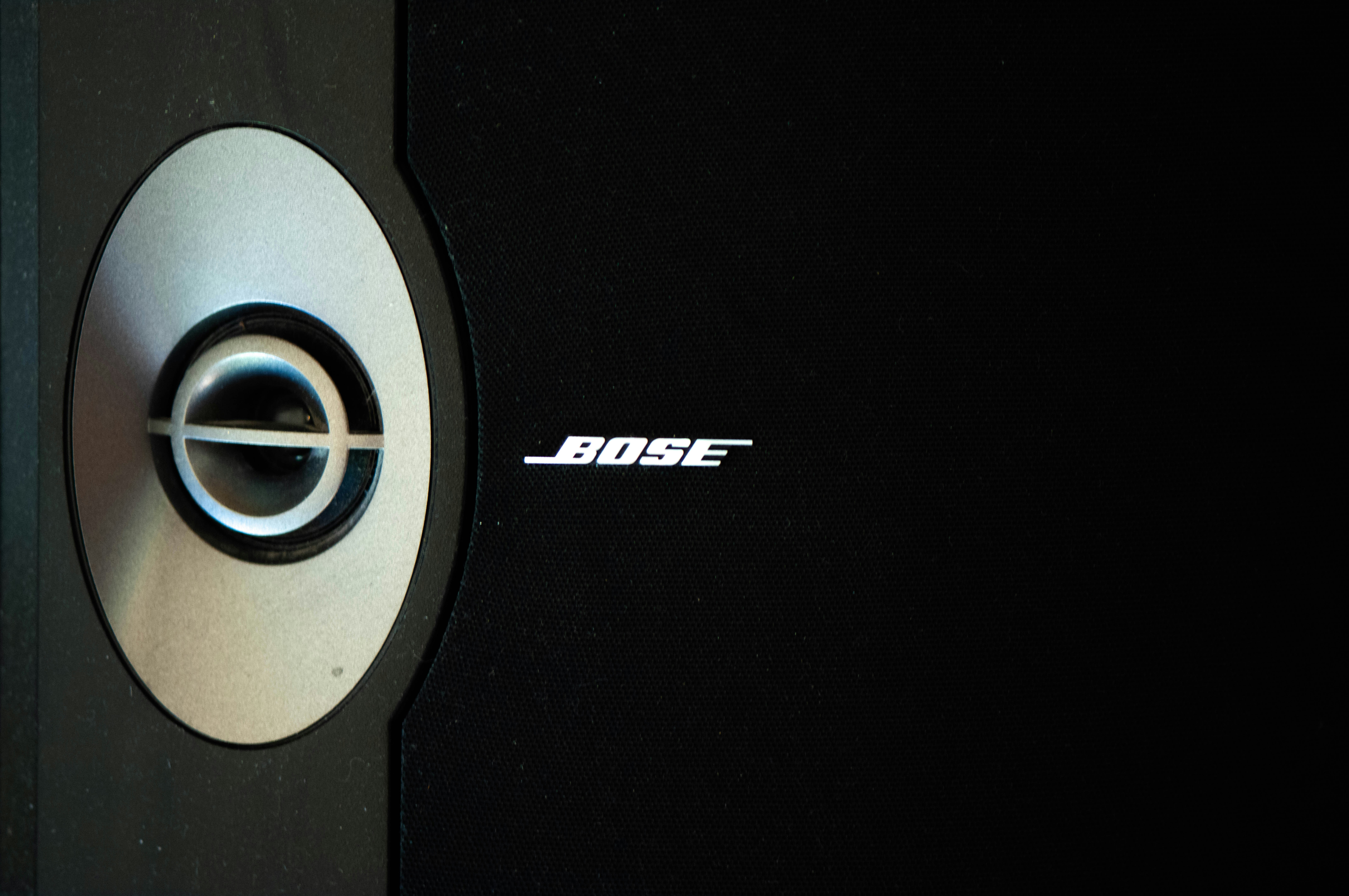 Close-up of a Bose speaker featuring a sleek design and prominent logo, emphasizing the brand's commitment to audio excellence.