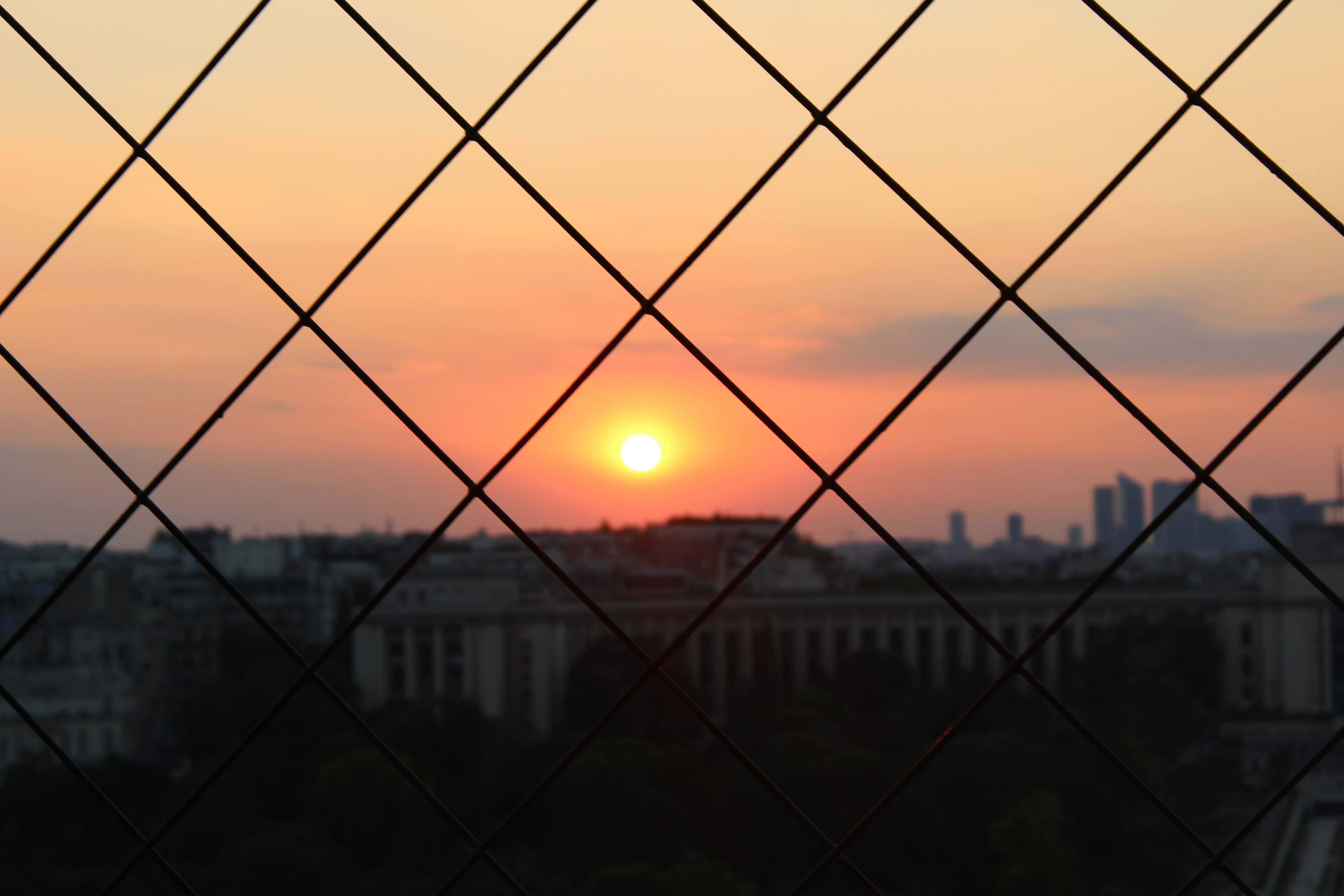 Dusk Framed by a Diamond Mesh Over a Sleeping City