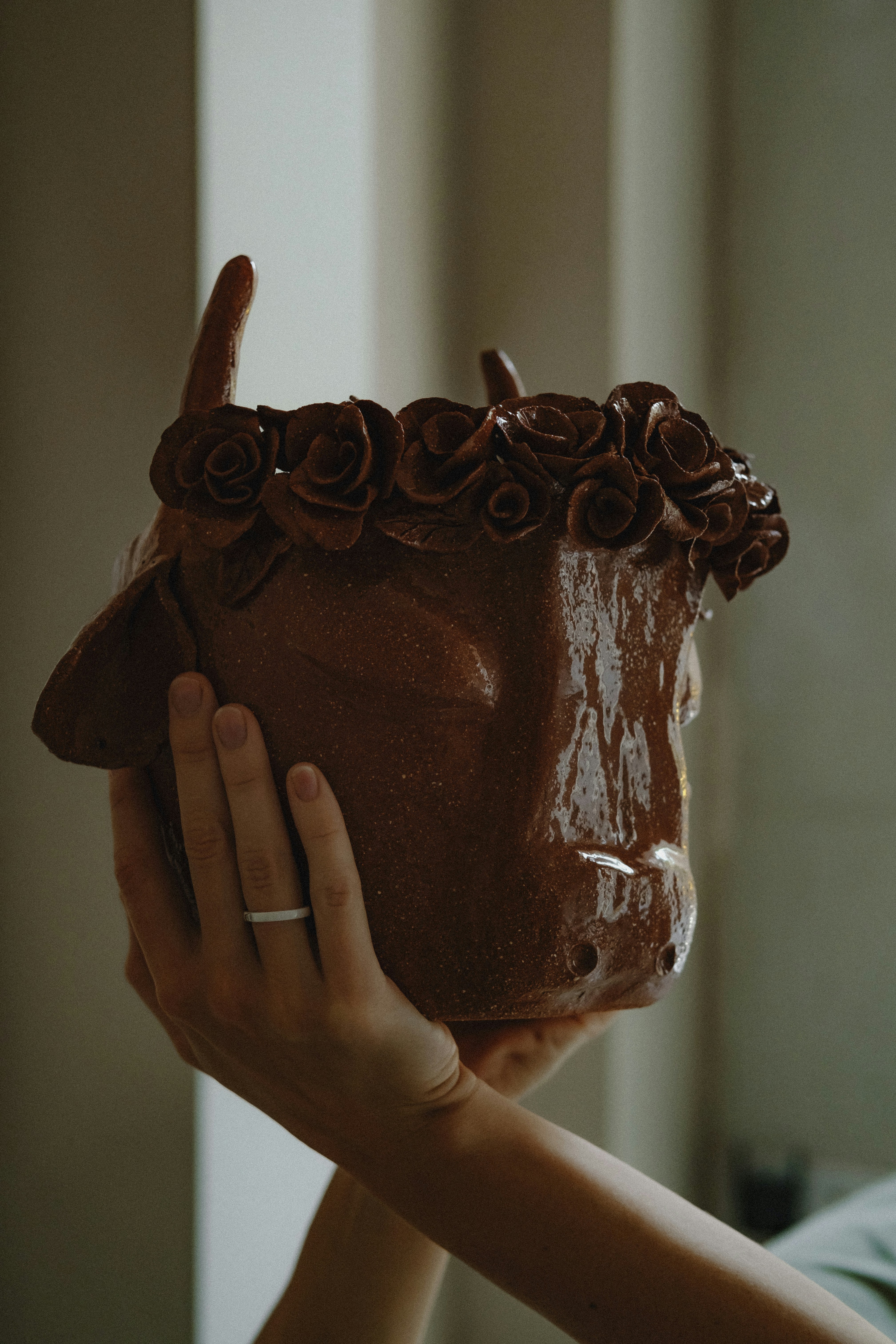 Chocolate Crown: A Cake Mask Embraced by Hands