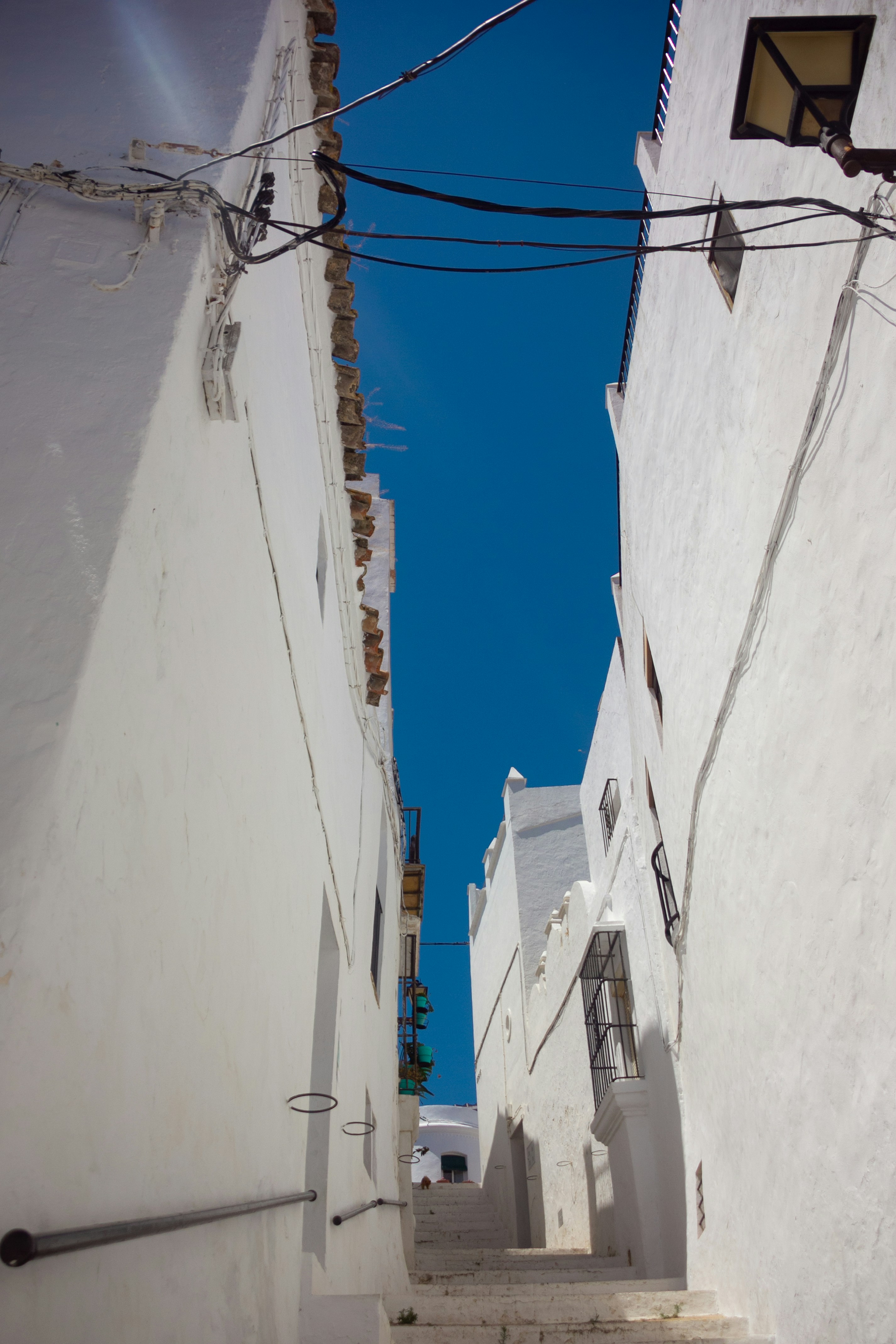 Blue Gap Between White Walls: A Narrow Aegean Alley