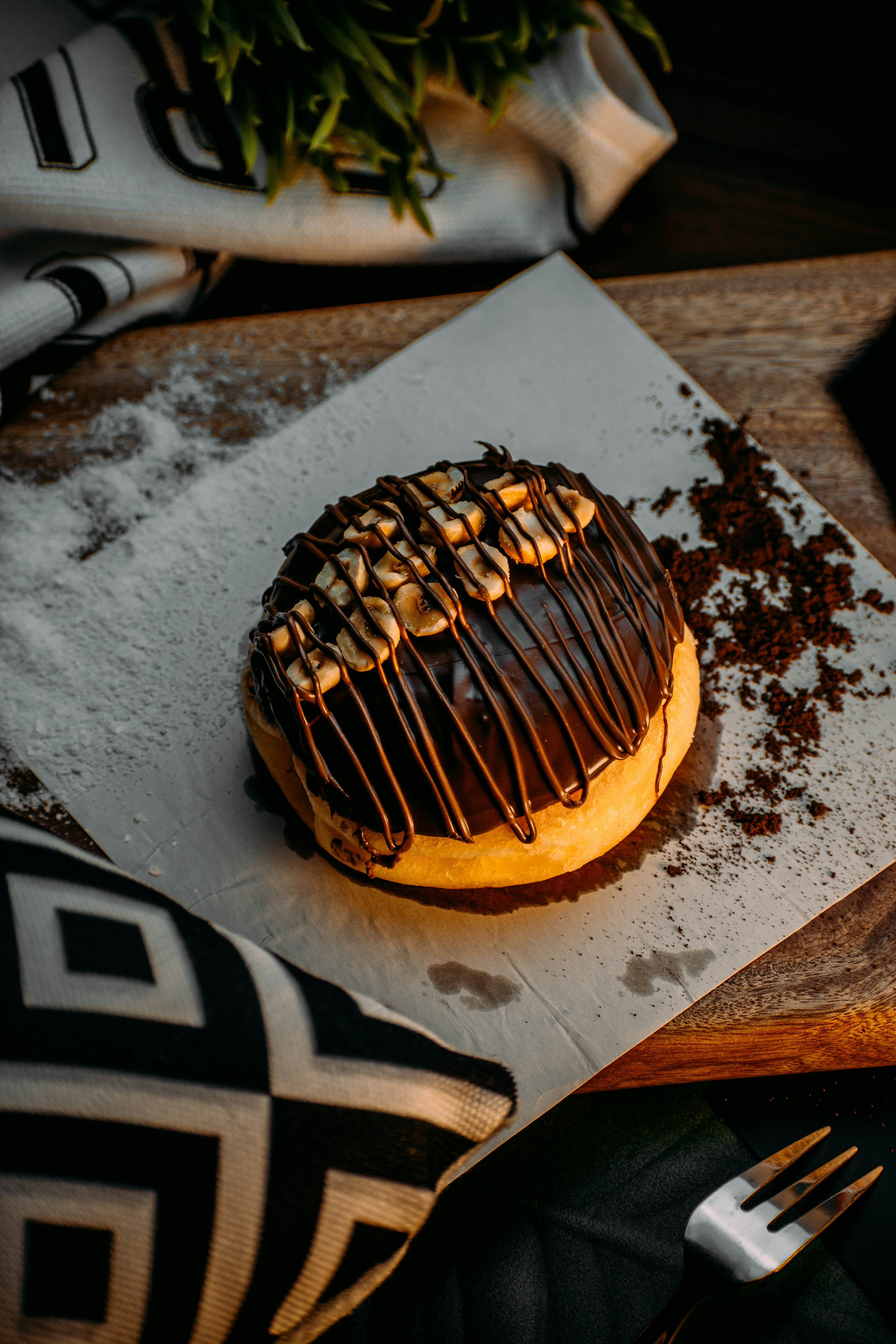 Chocolate Drizzle on a Parchment Stage: A Petite Cake with Cocoa Dust and Textured Backdrop