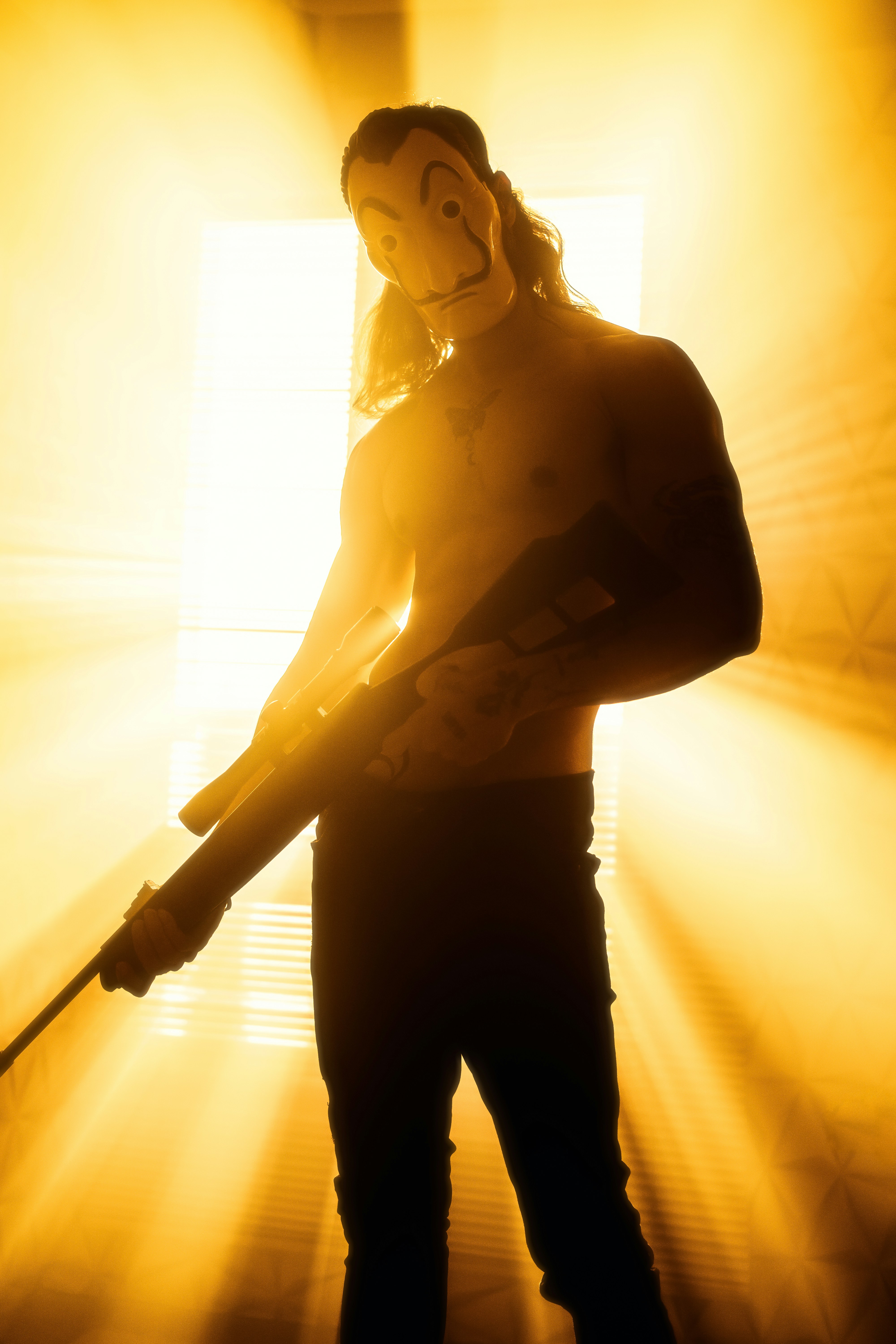 Sunburst Silhouette: A Masked Figure with a Long Prop in Golden Light