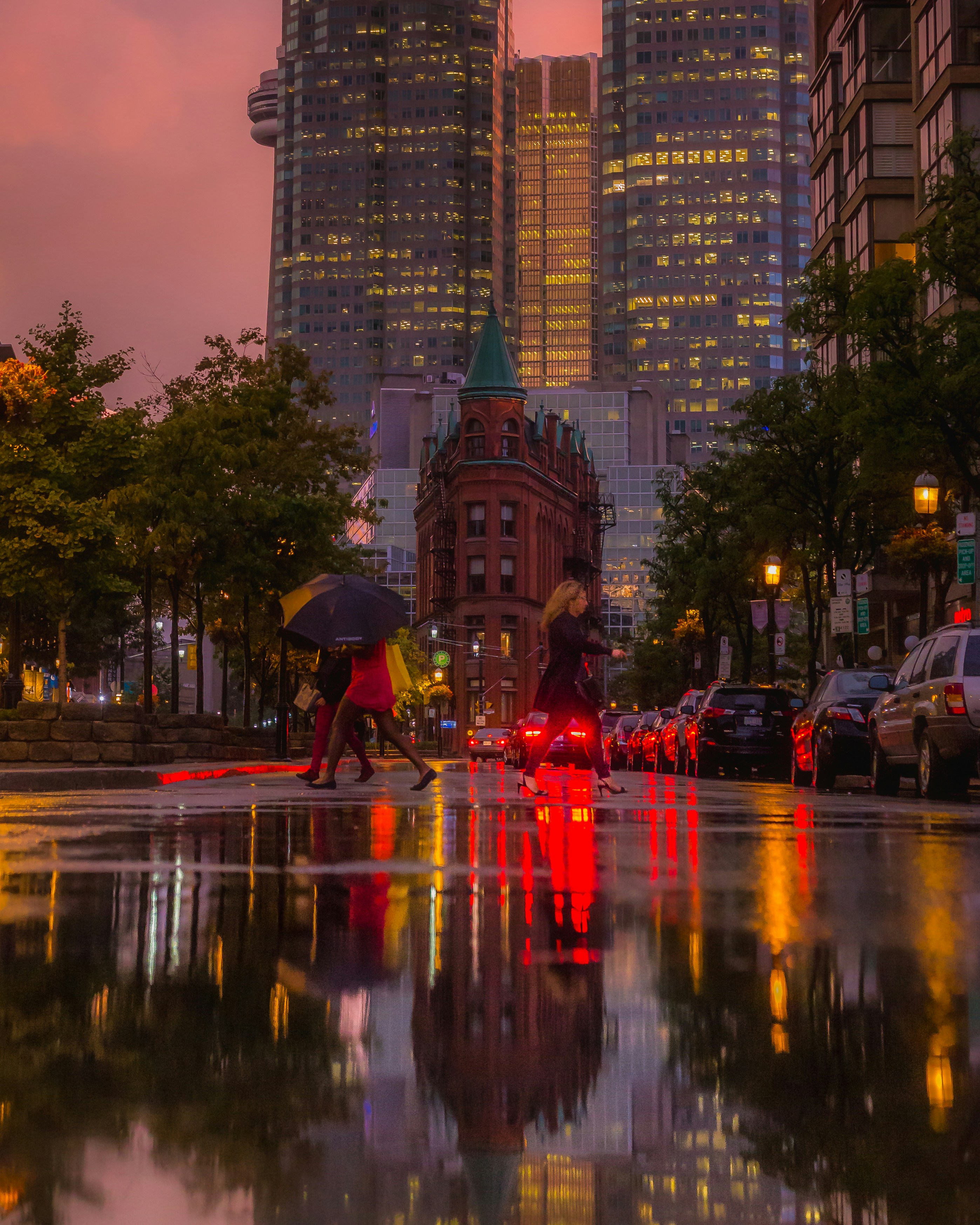 City Rain Reverberates: Neon Reflections and Red Taillights on Wet Streets