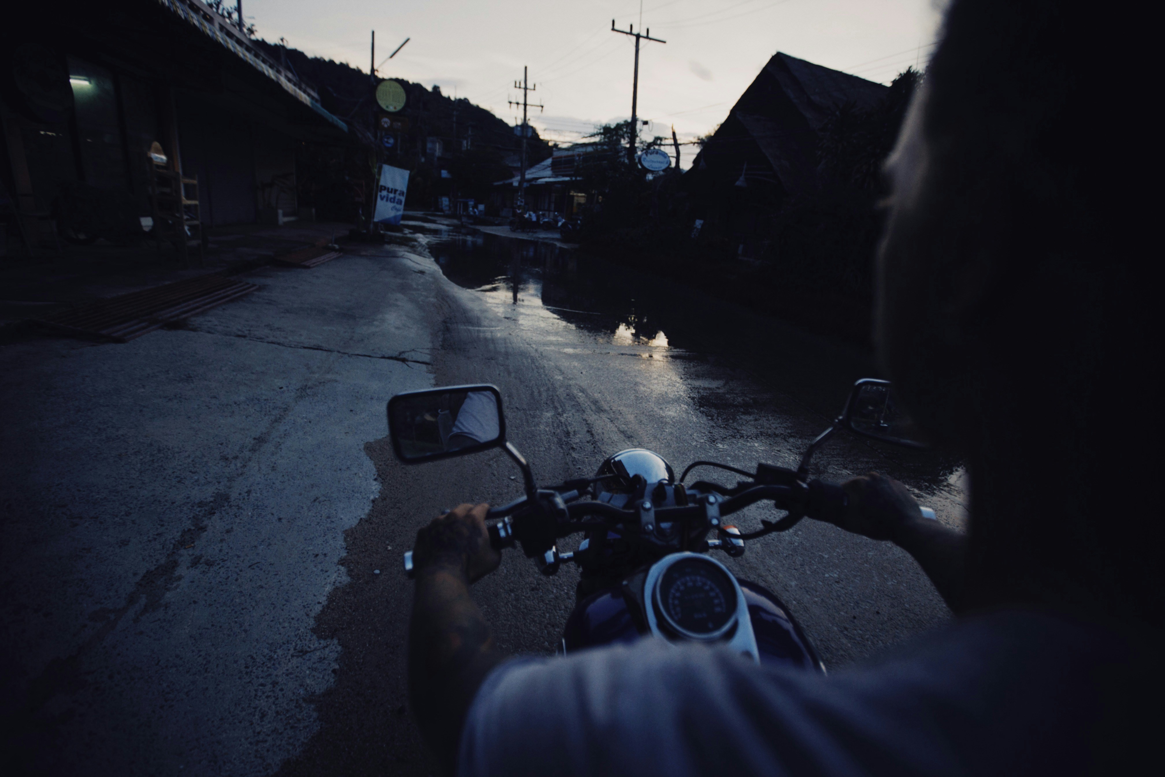 Rider's Night View: Rain-Slick Road and Neon Reflections