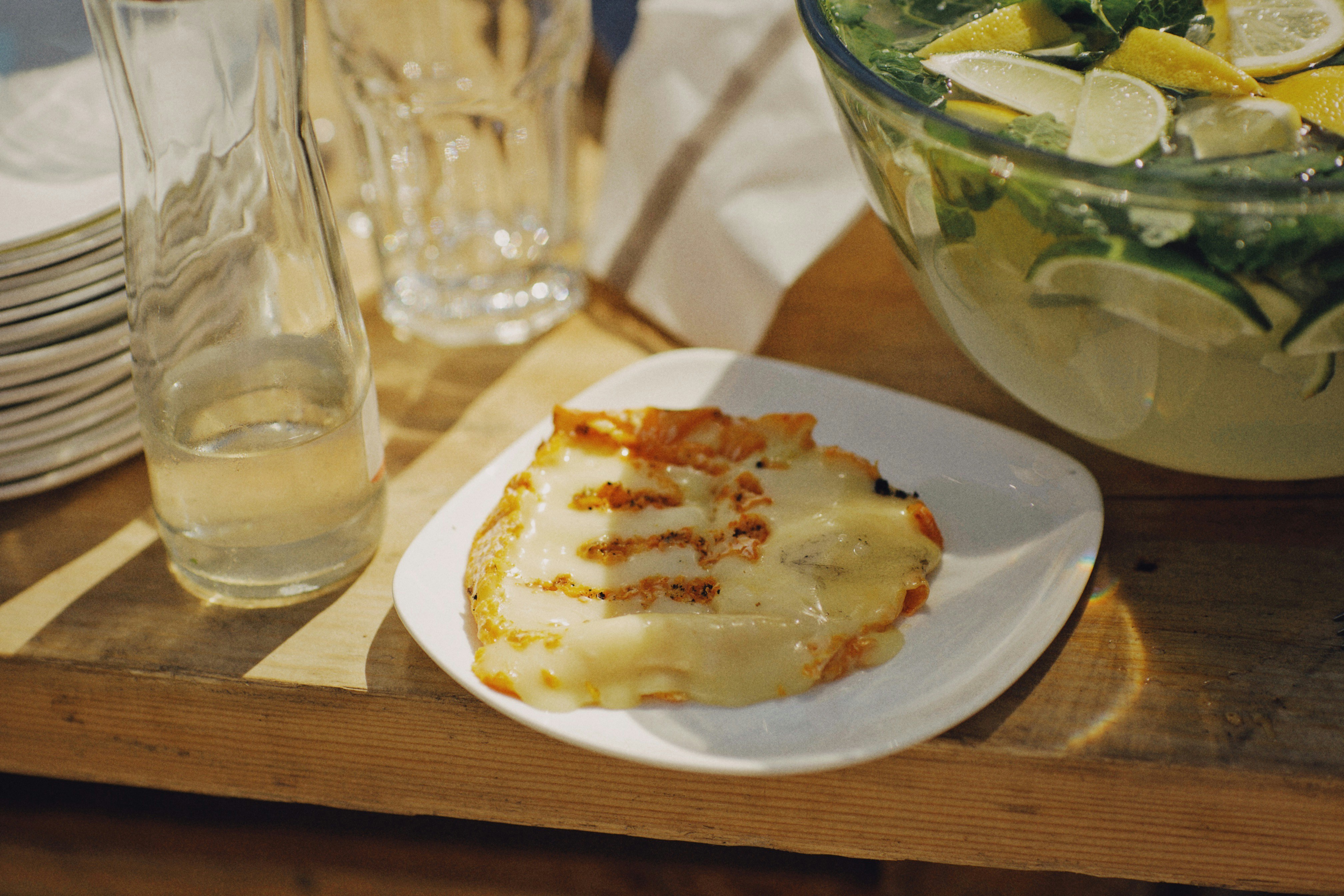 Melted Cheese on a White Plate by a Lemon-Infused Cooler